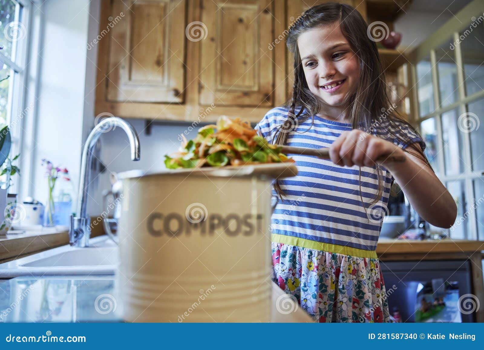 Girl in Kitchen Making Compost Scraping Vegetable Leftovers into Bin ...