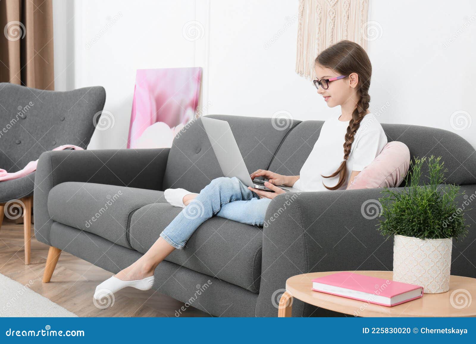 Girl with laptop on sofa stock photo. Image of learn - 225830020