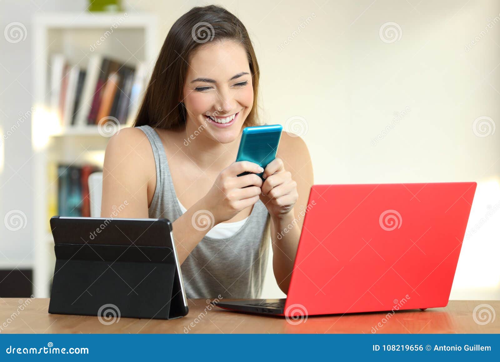 Girl Laughing Using Multiple Devices at Home Stock Photo - Image of ...