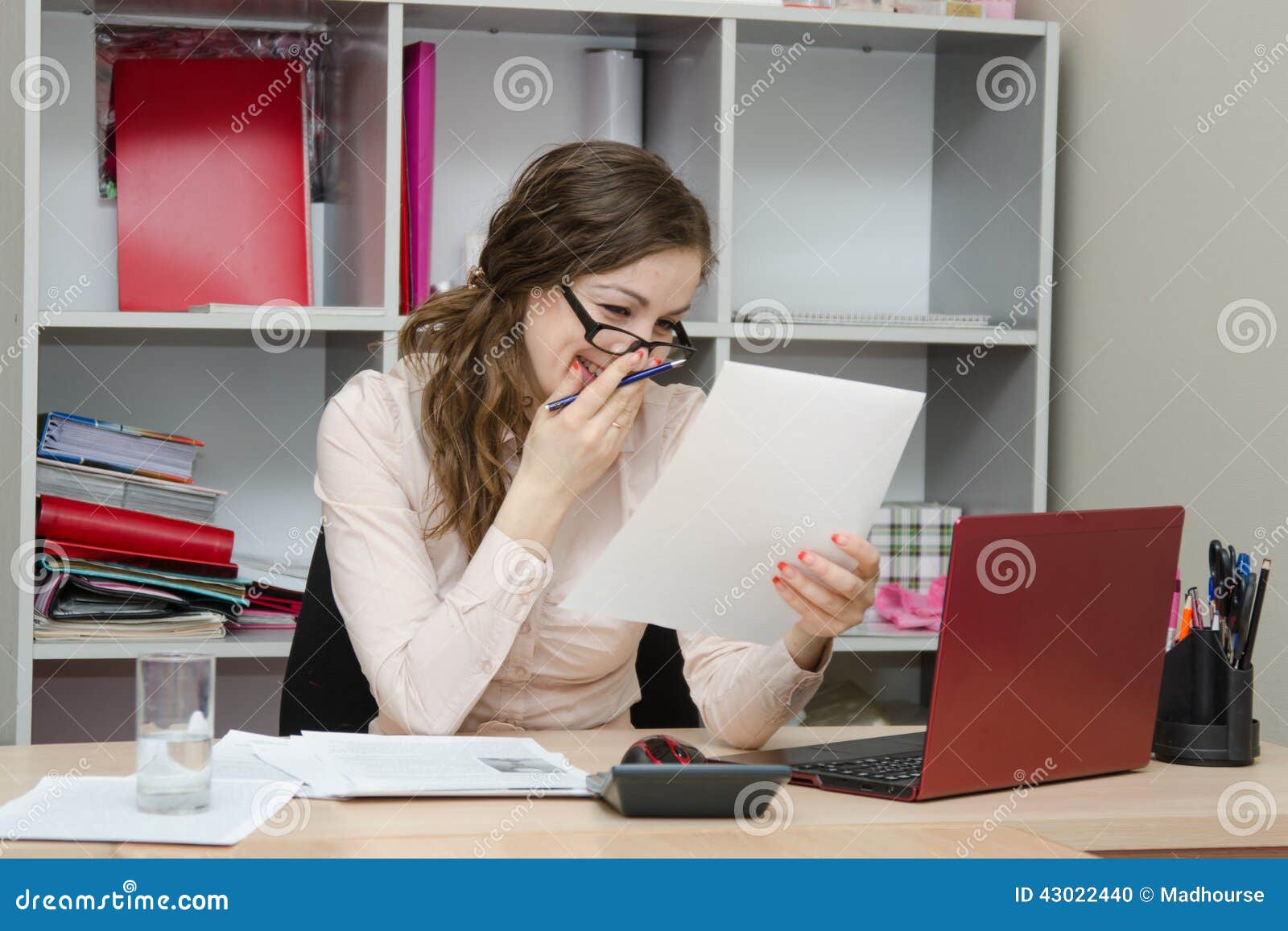Girl Laughs while Reading a Document in the Workplace Stock Photo ...