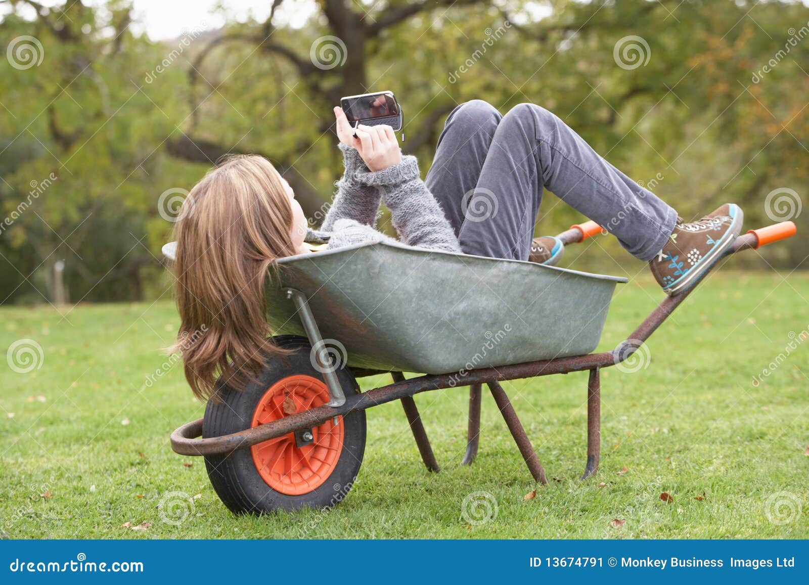 Girl Laying Wheelbarrow Using Smart Phone Stock Image - Image of cell ...