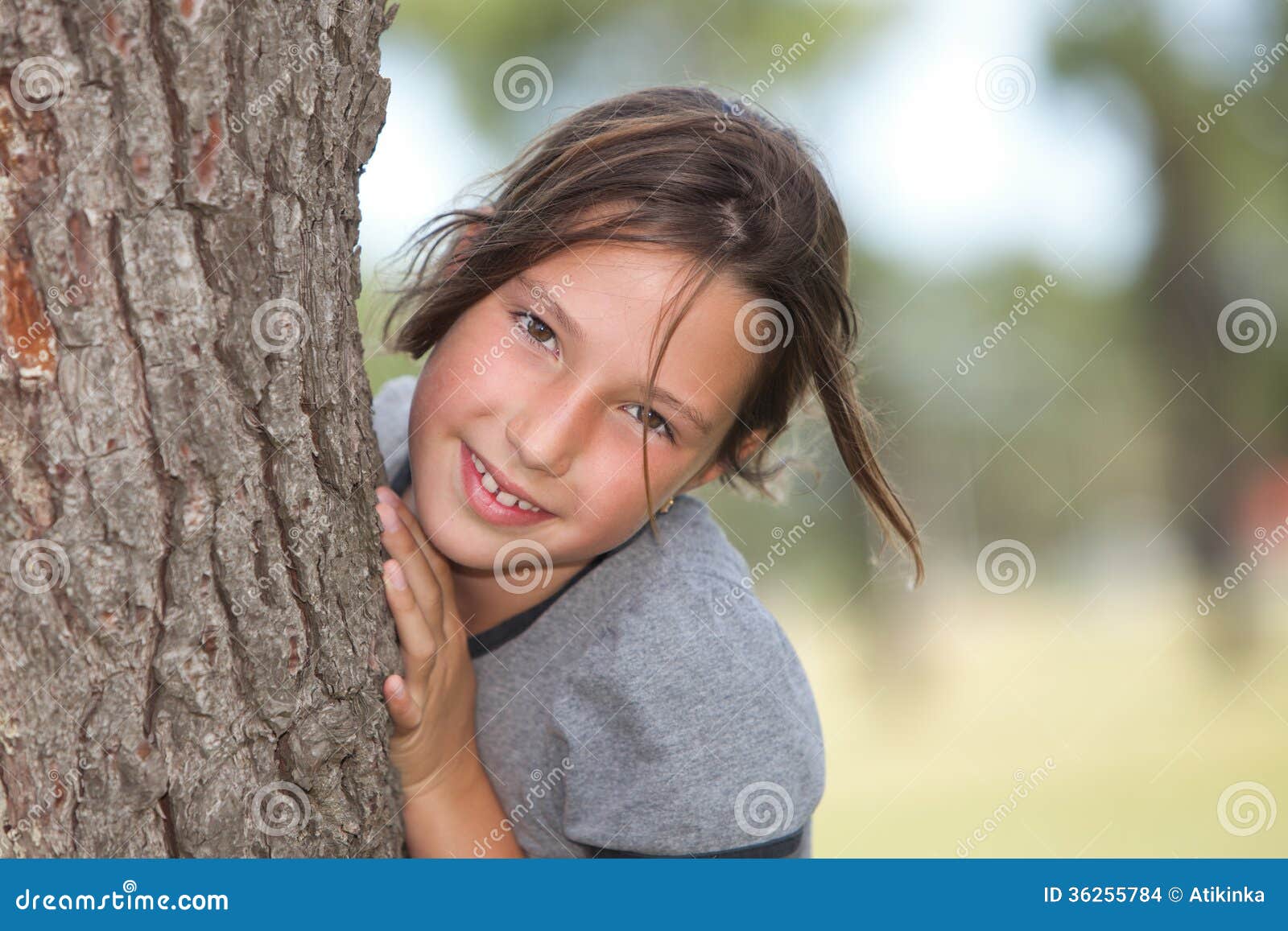 Girl Looking from Behind a Tree Stock Photo - Image of play, childhood ...