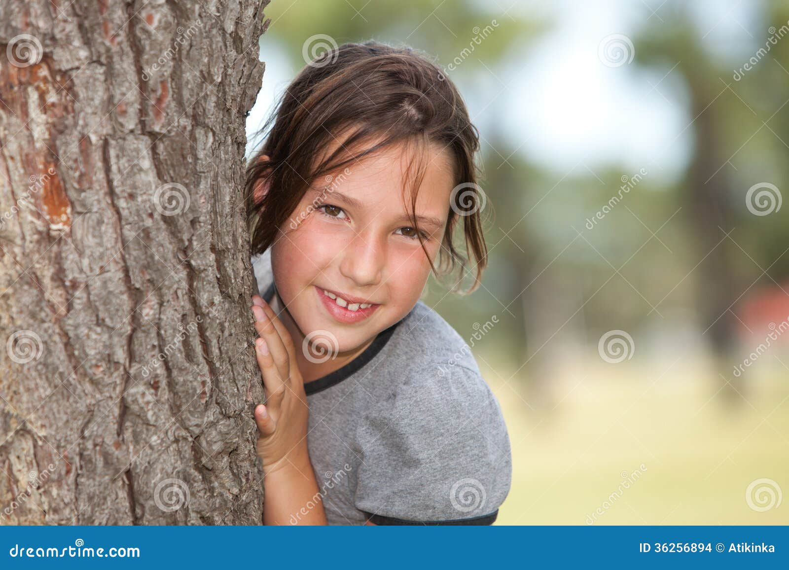 Girl Looking from Behind a Tree Stock Photo - Image of looking ...