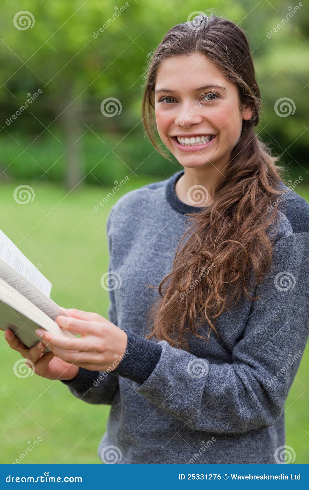 Girl Looking at the Camera while Reading a Book Stock Photo - Image of ...