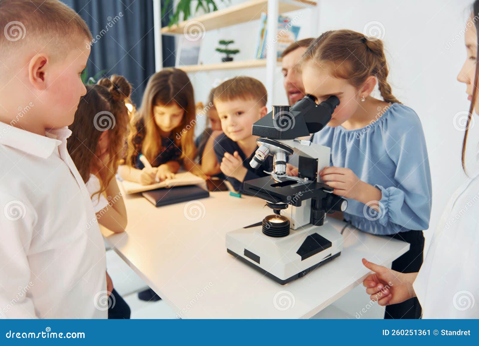Girl Looking into Microscope. Group of Children Students in Class at ...