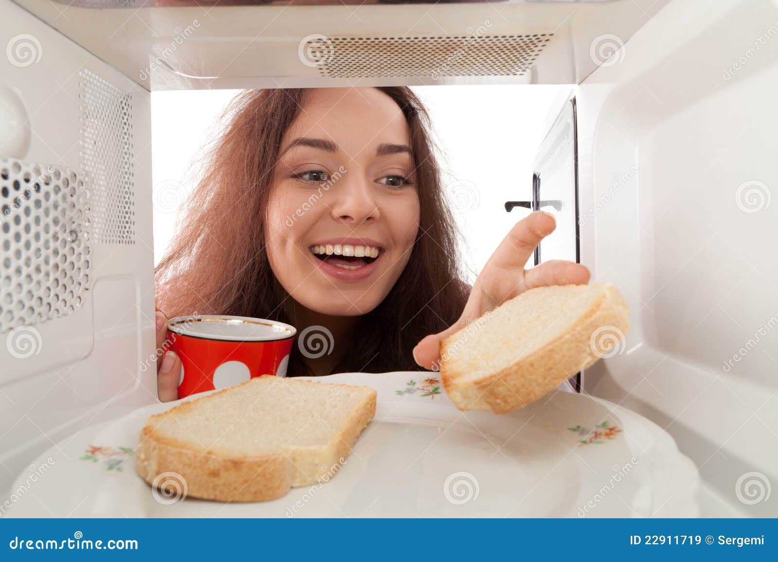 Girl looks in a microwave stock image. Image of feminine - 22911719
