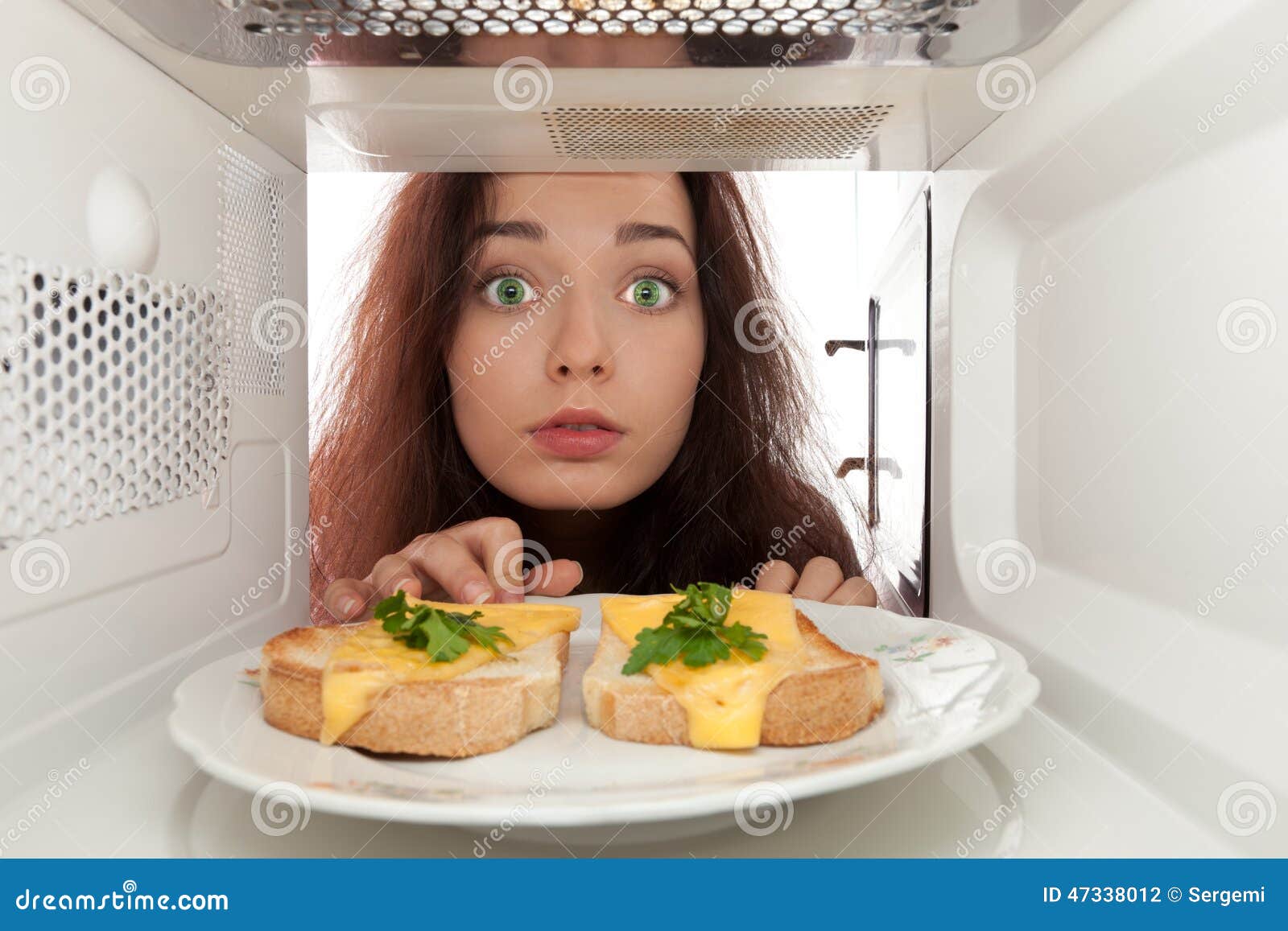 Girl looks in a microwave stock photo. Image of cooking - 47338012