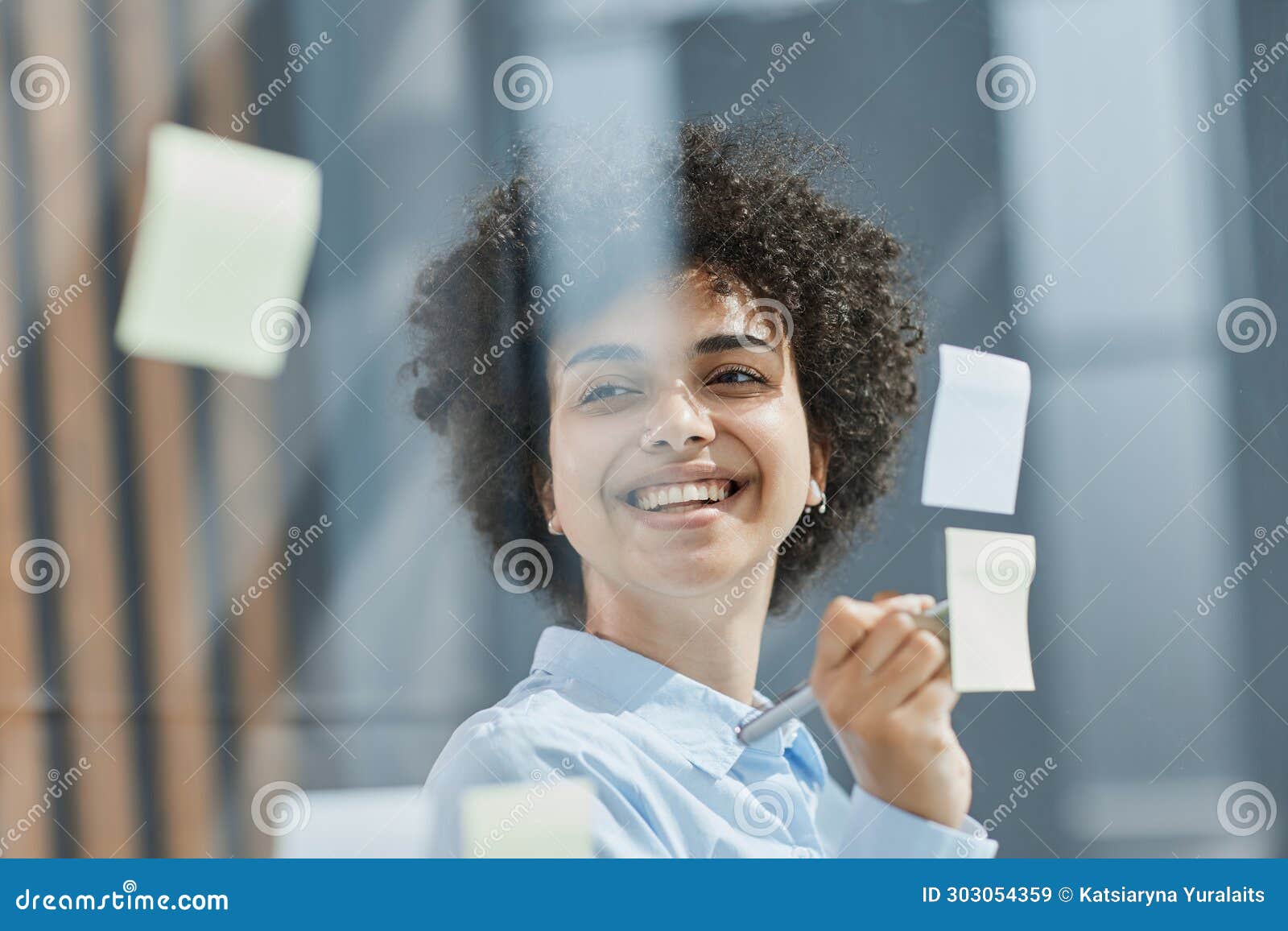 A Girl in a Modern Office Behind Glass Uses Sticky Notes and Makes ...