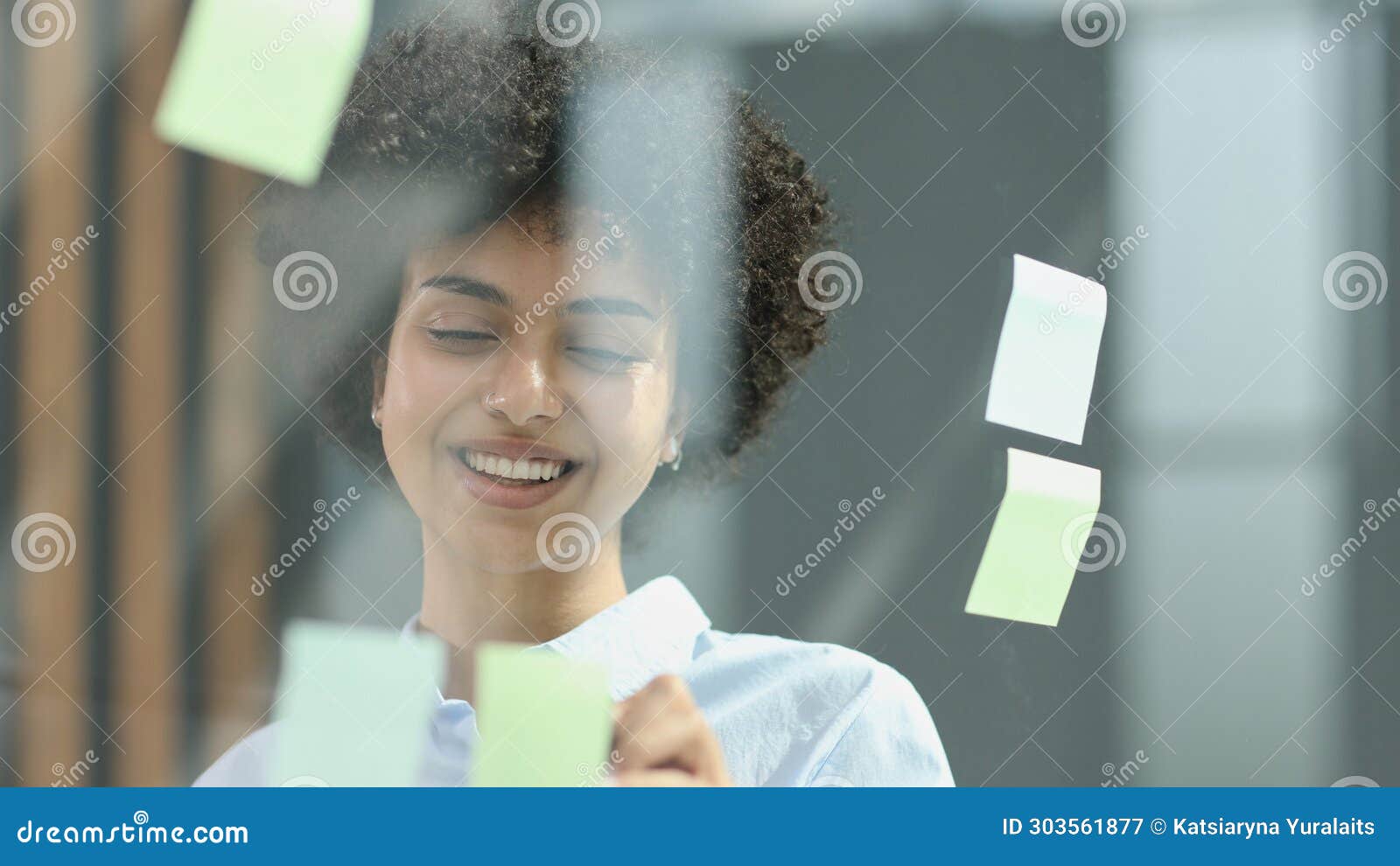 A Girl in a Modern Office Behind Glass Uses Sticky Notes and Makes ...