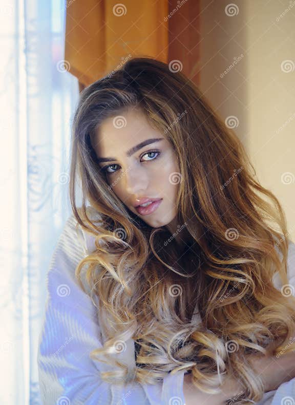 Girl With Mysterious Face And Long Curly Hair In Bathrobe Stock Image