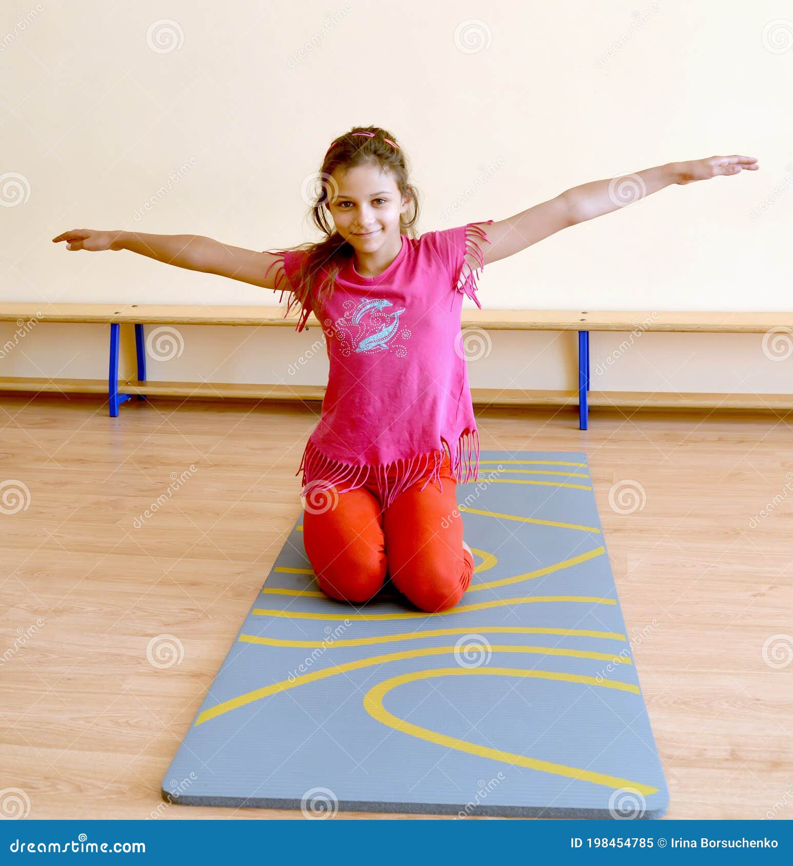 The Girl Performs an Exercise on a Gymnastics Mat in the Gym Stock ...