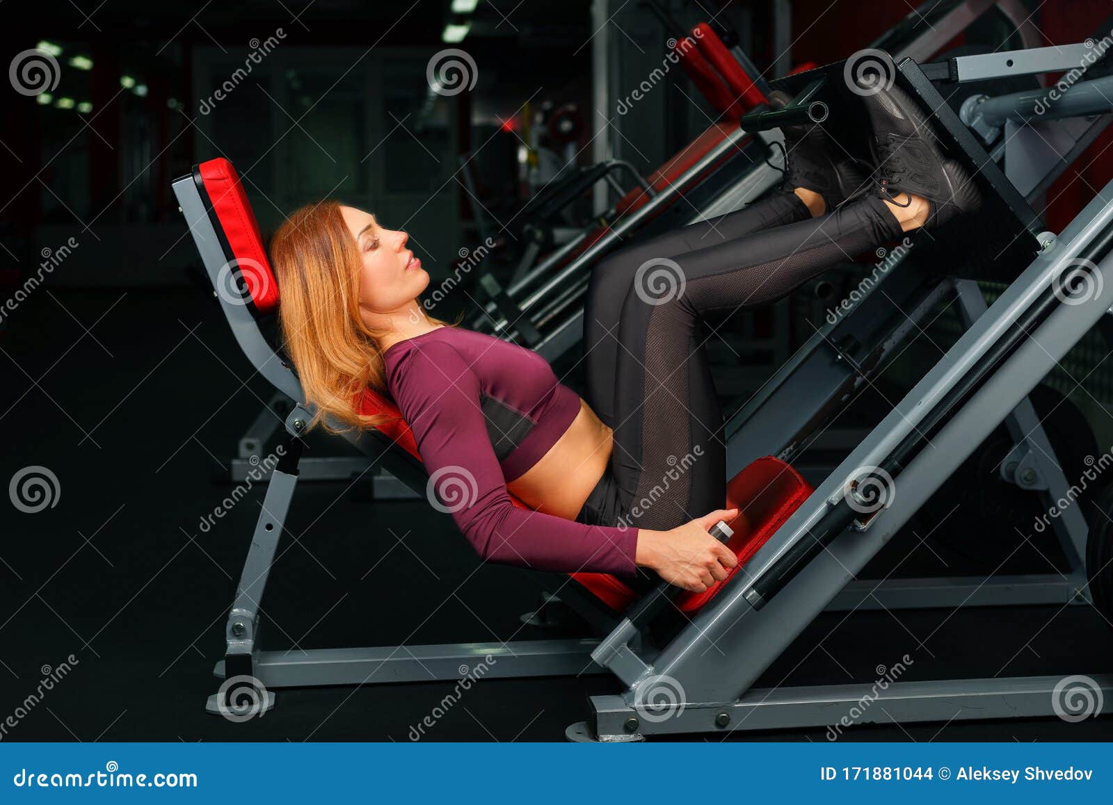The Girl Performs an Exercise on the Simulator for the Legs Stock Photo ...