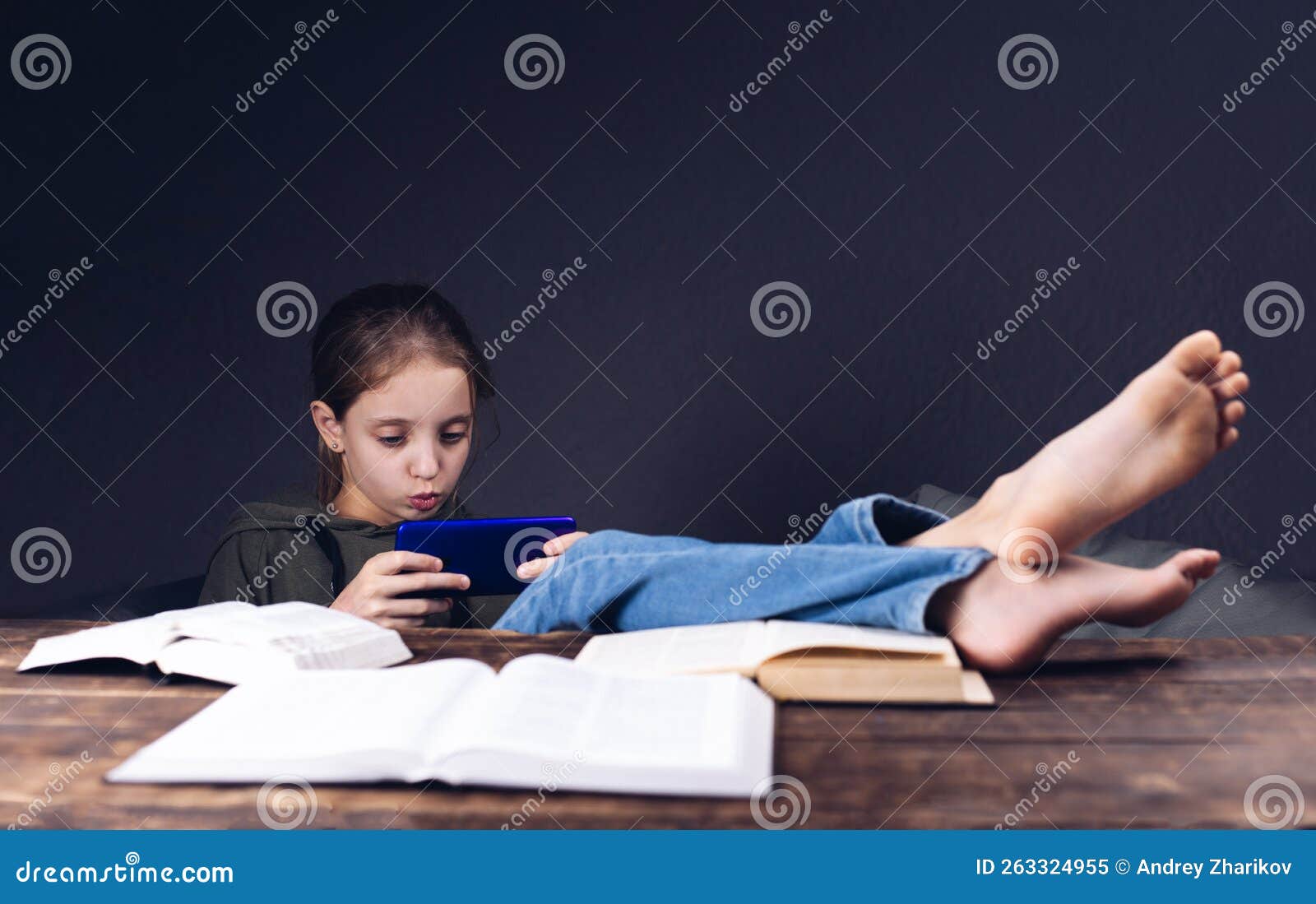 A Girl with a Phone in Her Hands. the Girl Plays on the Phone, Ignoring ...