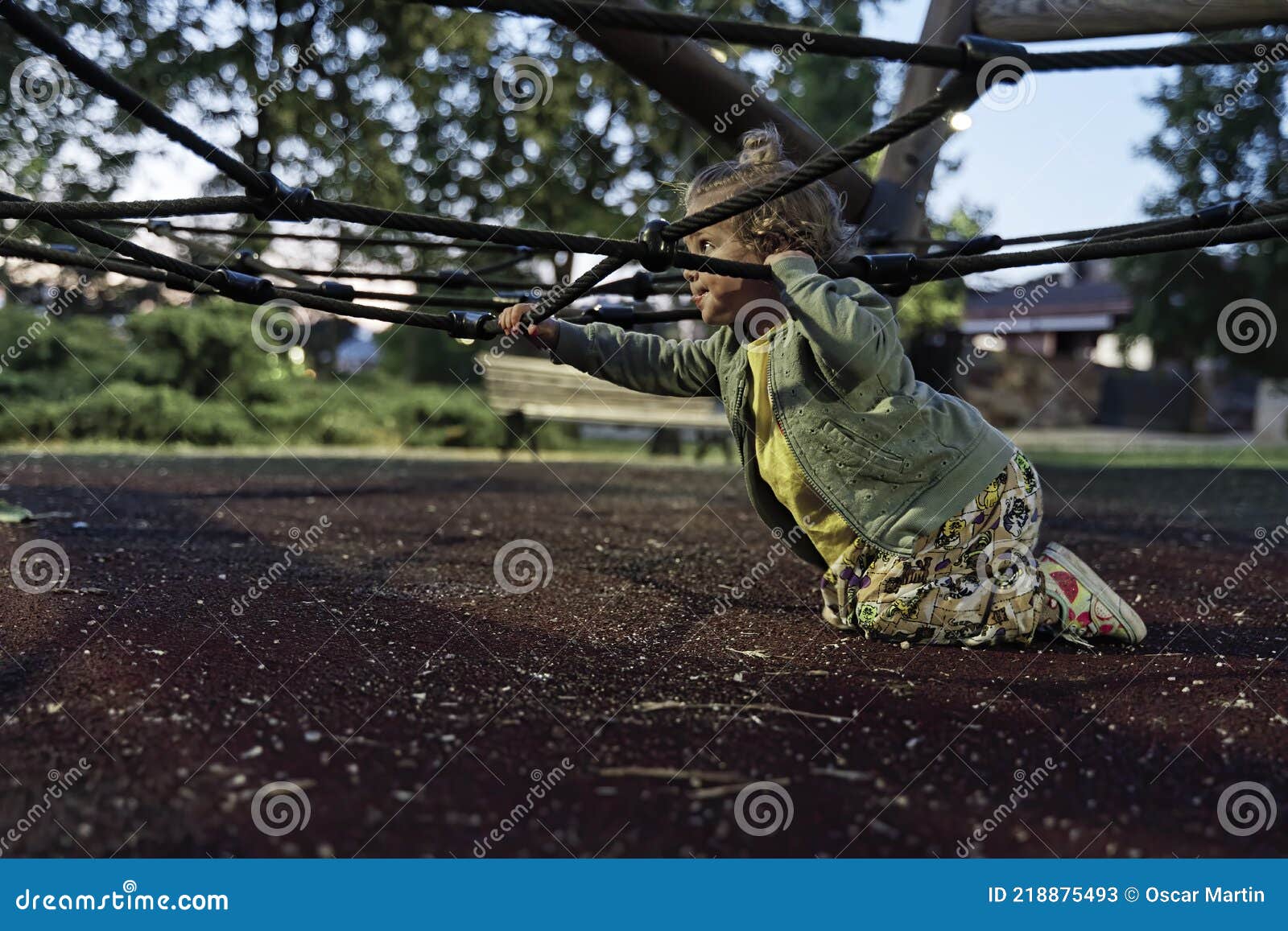 Girl in a Playground while Having Fun Going through a Rope Net on Her ...