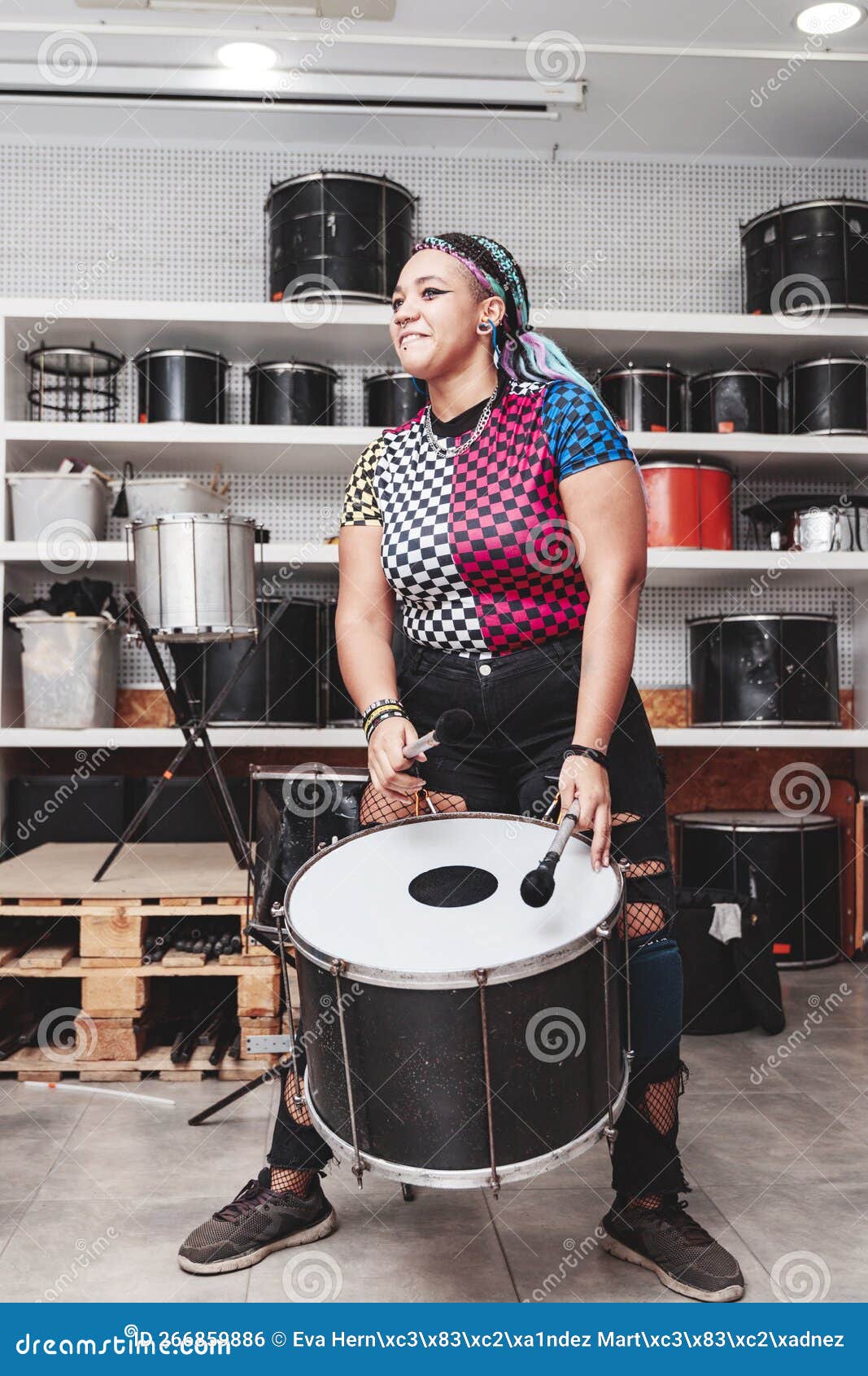A Girl Playing a Drum with Maces Surrounded by Percussion Instruments ...