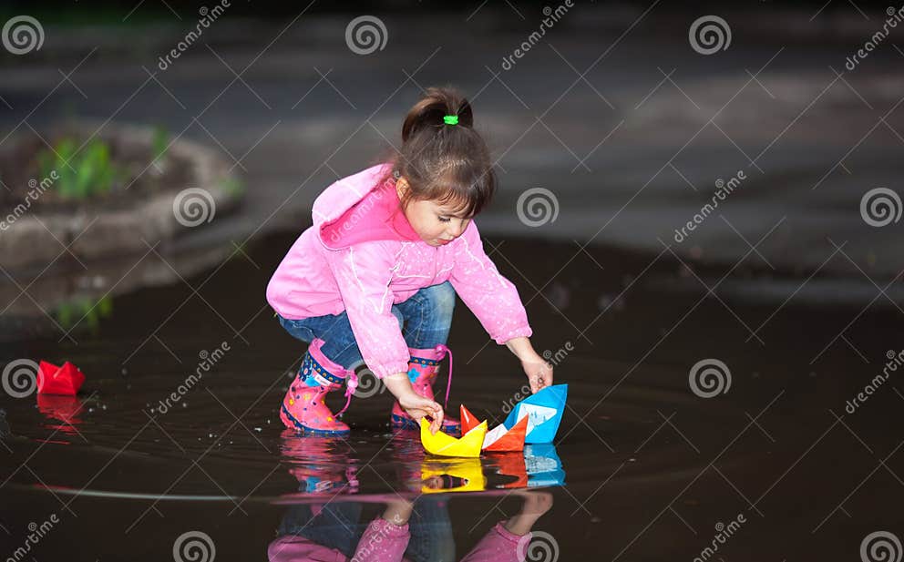 Girl playing in puddle stock photo. Image of happiness - 25184542
