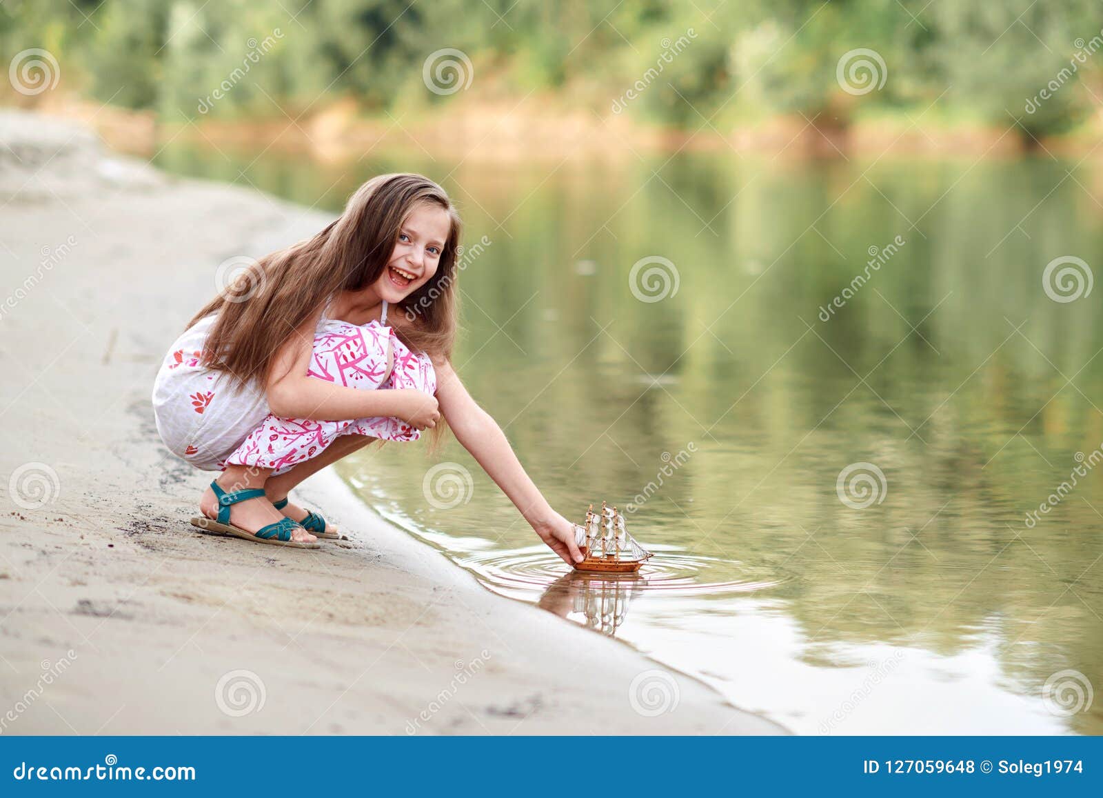 Girl Playing with a Toy Sailing Ship by the River Stock Photo - Image ...