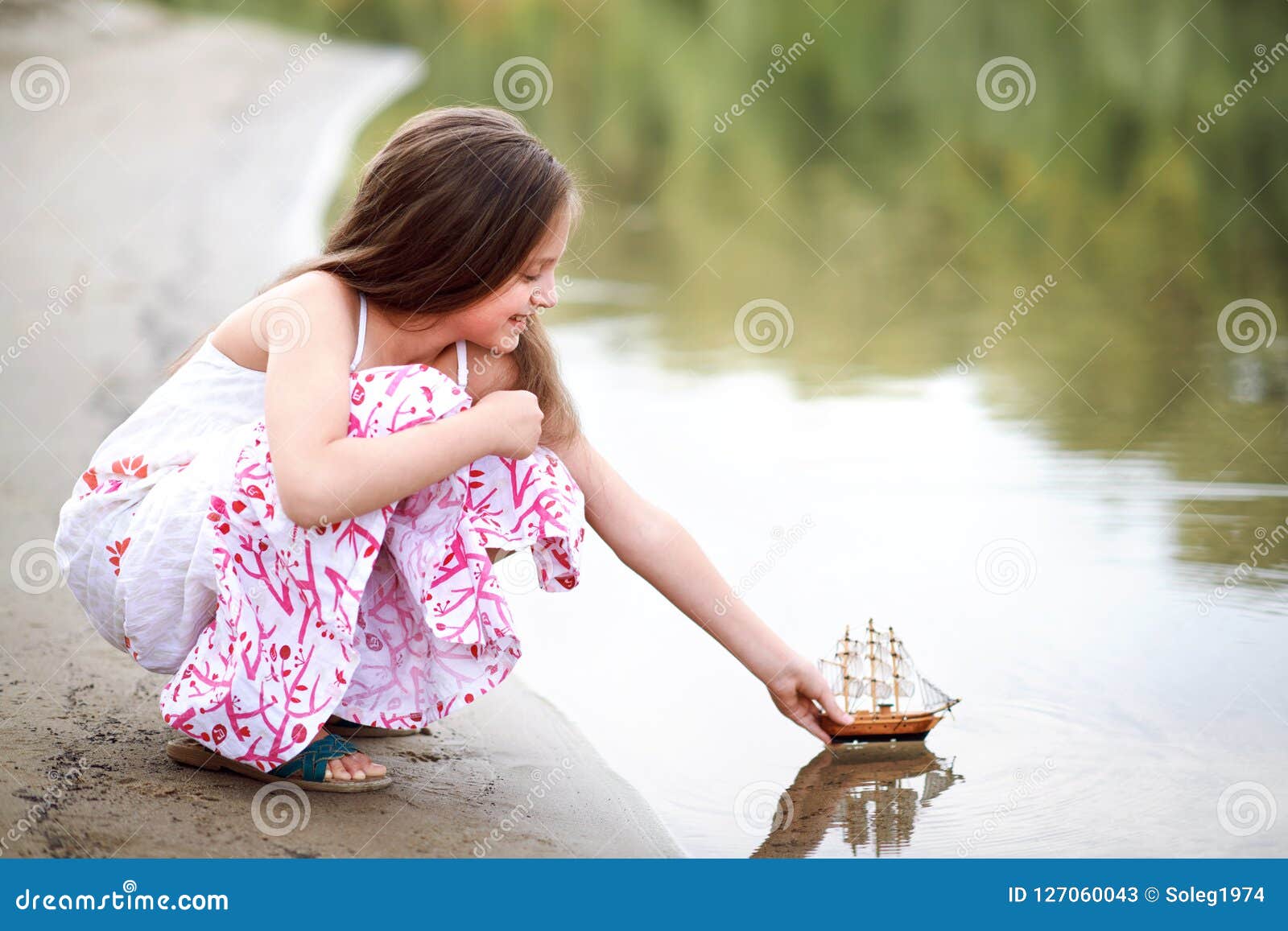 Girl Playing with a Toy Sailing Ship by the River Stock Image - Image ...