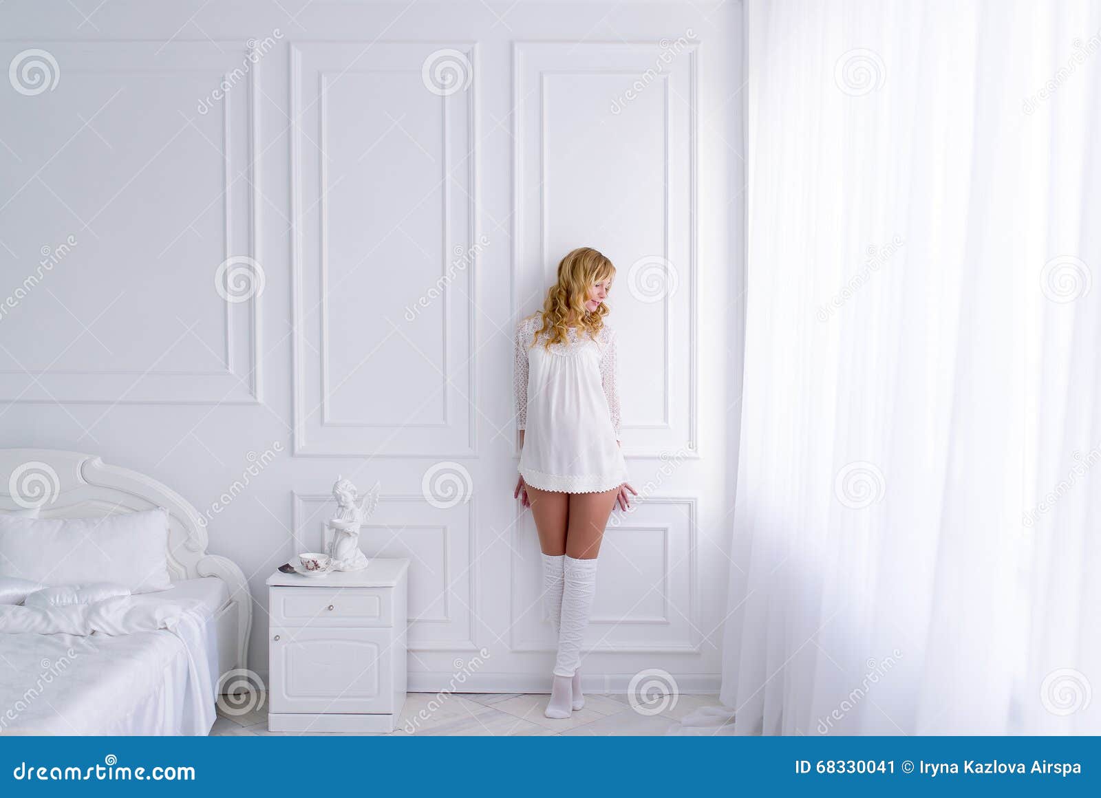 The Girl Poses in a White Magnificent Bedroom. Stock Image - Image of ...