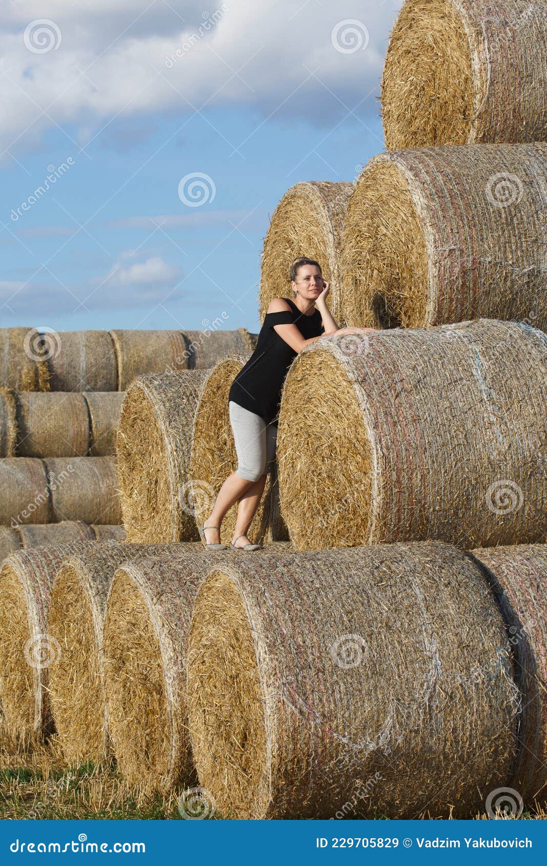 Girl Posing Near a Stack of Straw. Straw Rolls, Stacked in a Pyramid ...