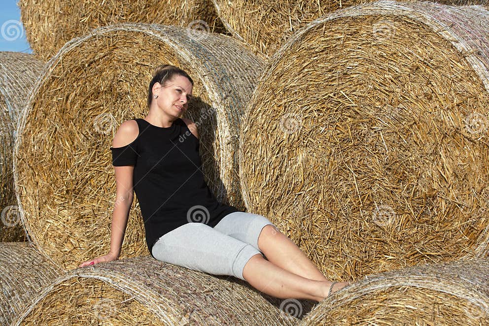 Girl Posing Near a Stack of Straw. Straw Rolls, Stacked in a Pyramid ...