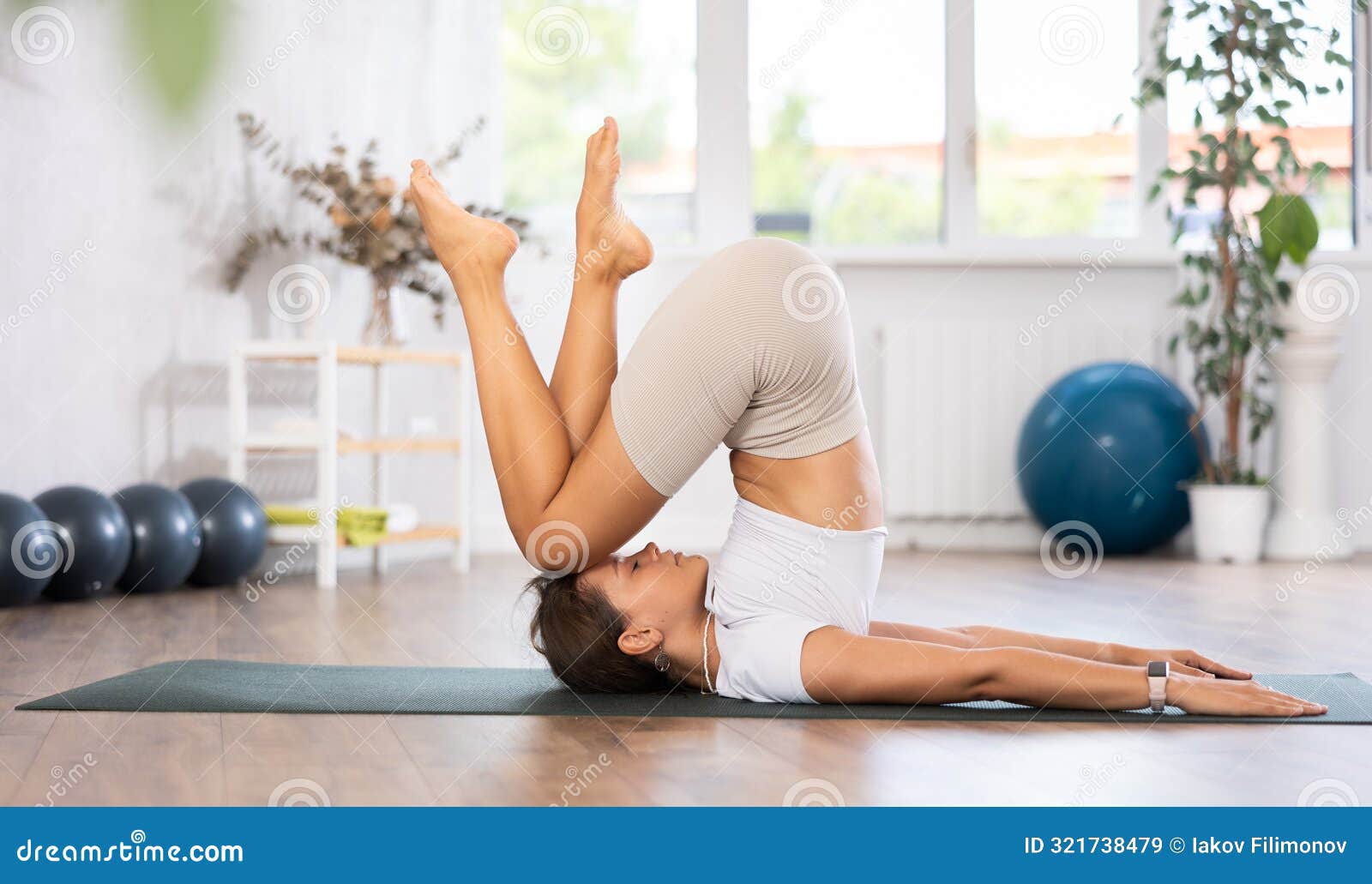 Girl Practicing Yoga with in Studio, Performing Wind Release Pose Ardha ...
