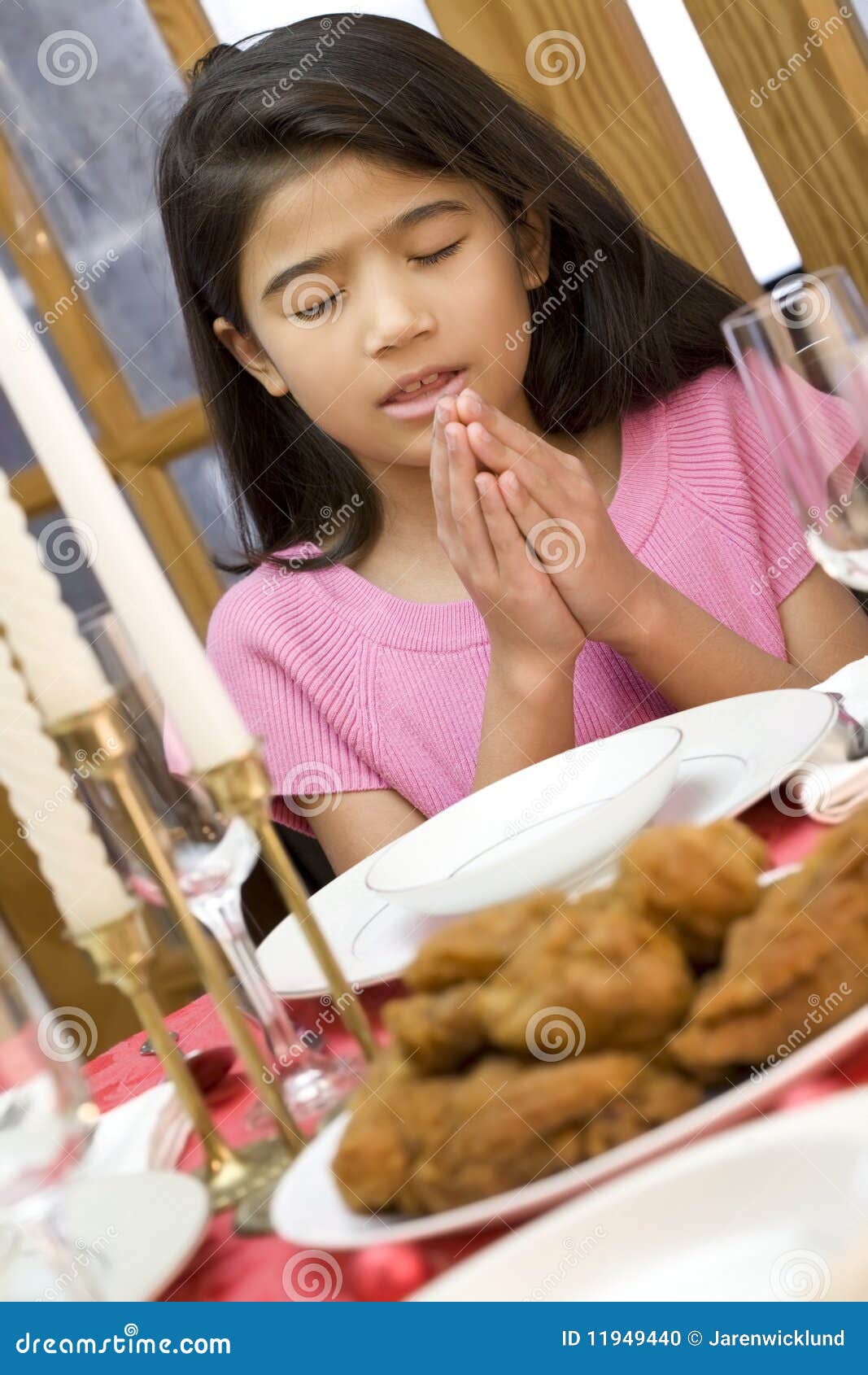 Girl praying during dinner stock photo. Image of table - 11949440