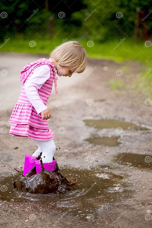 Girl in a puddle stock image. Image of jump, dress, funny - 12034847