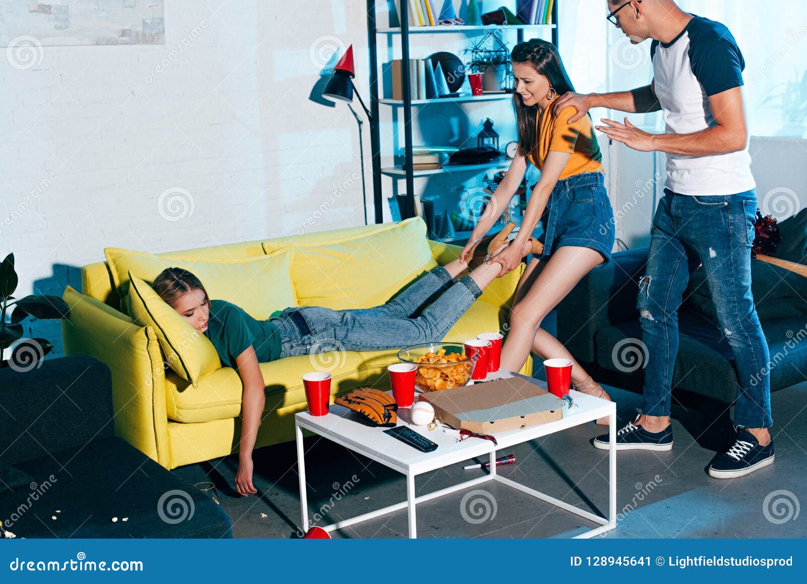 Girl Pulling Drunk Female Friend Sleeping on Sofa after Stock Image ... Girl Pulling Drunk Female Friend Sleeping on Sofa after Stock Image ...