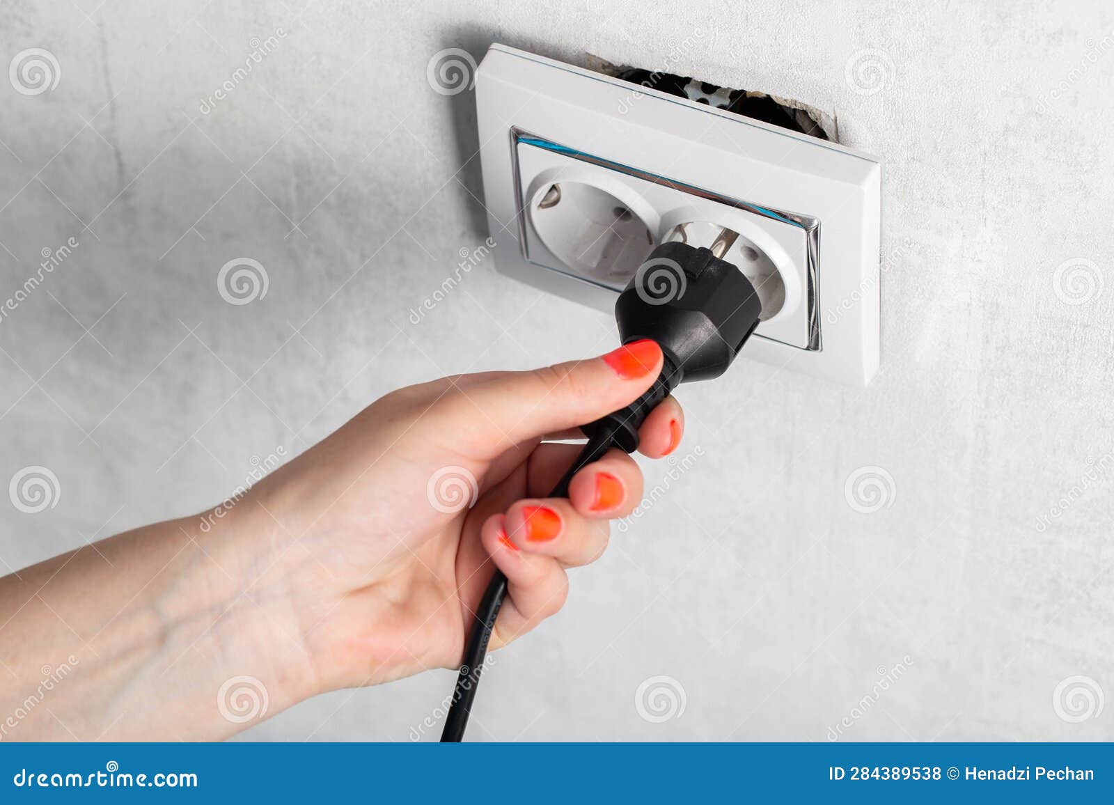 The Girl Puts the Electric Plug into a Broken Socket. Risk of Electric ...