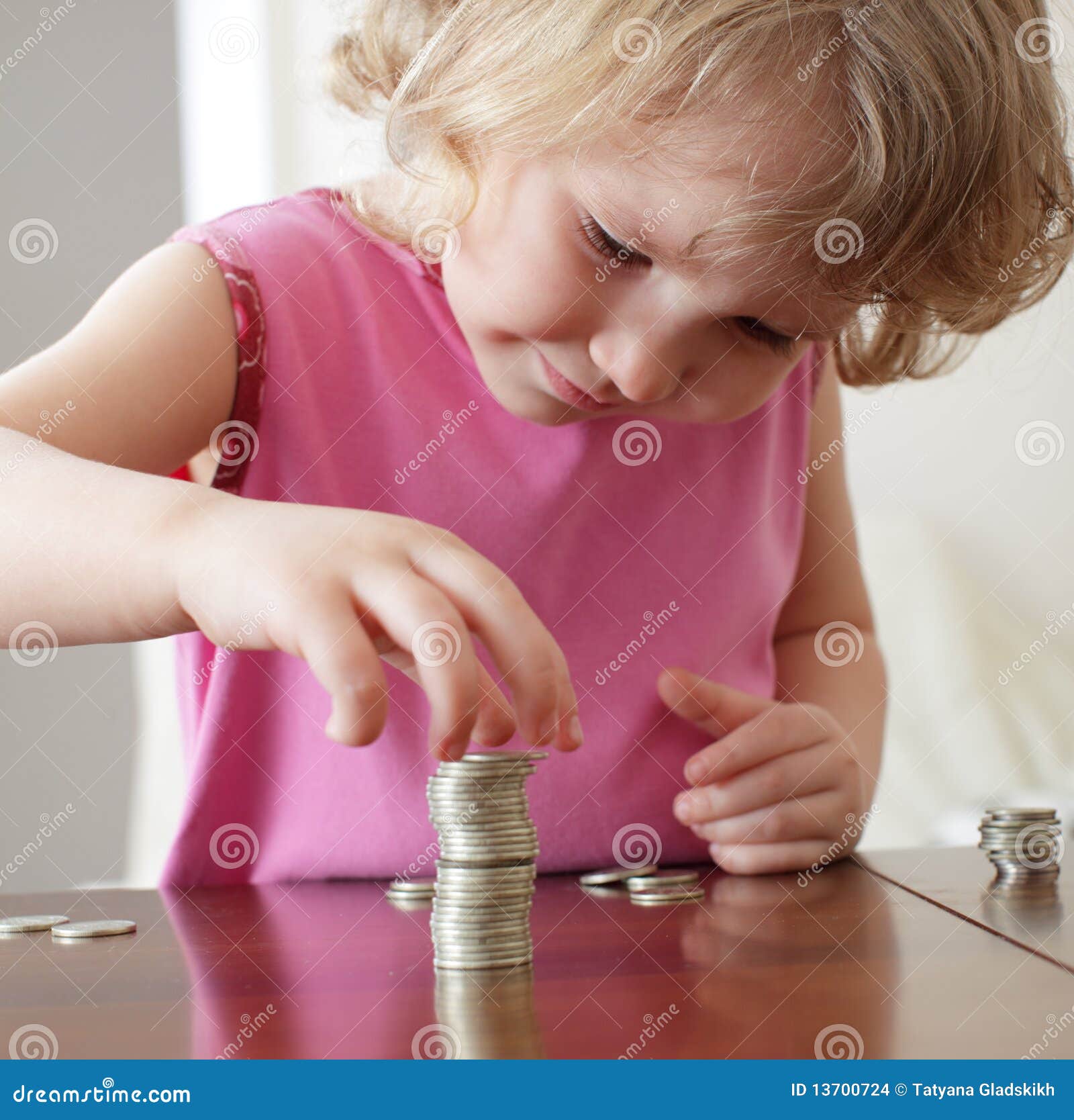 Girl putting coins stock photo. Image of table, bank - 13700724