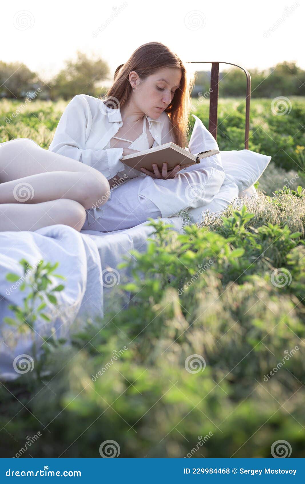 Girl Reading a Book in Bed among the Fields Stock Photo - Image of ...
