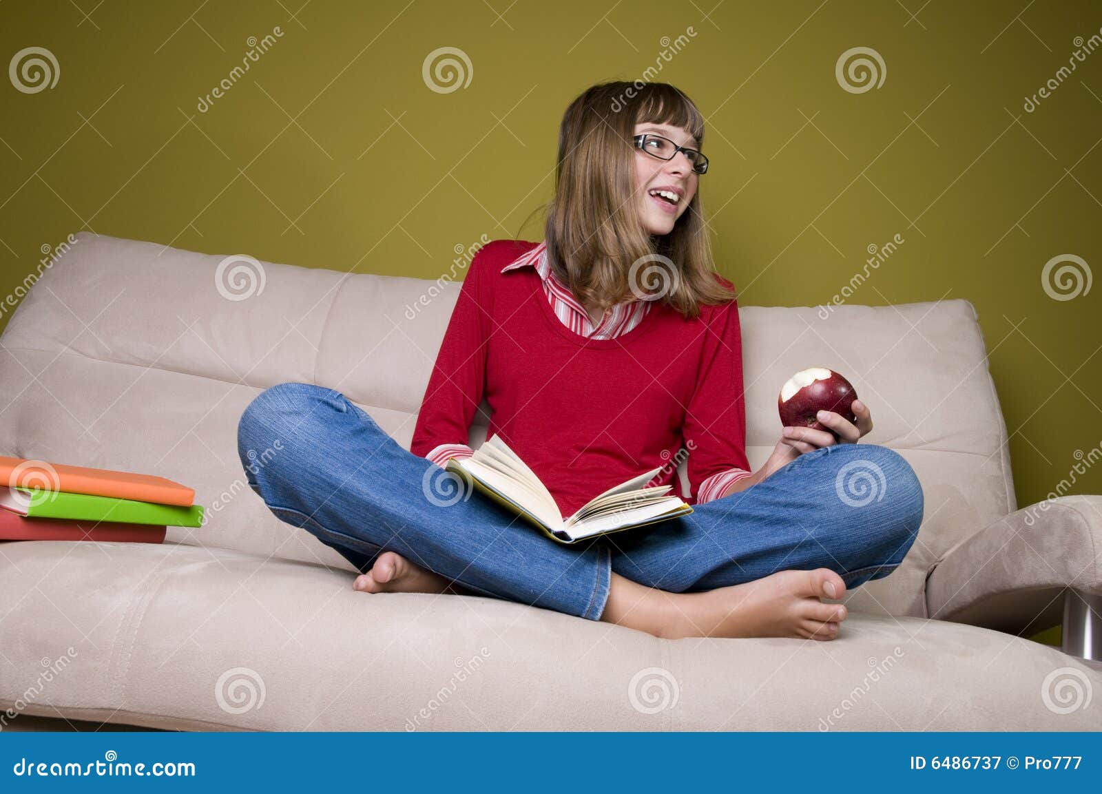 Girl reading book on sofa stock image. Image of glasses - 6486737