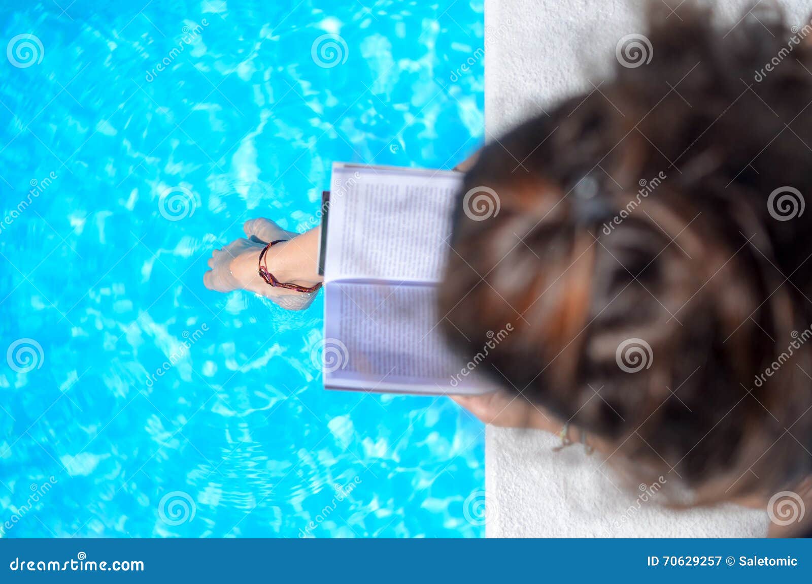 Girl reading by the pool stock image. Image of exterior - 70629257