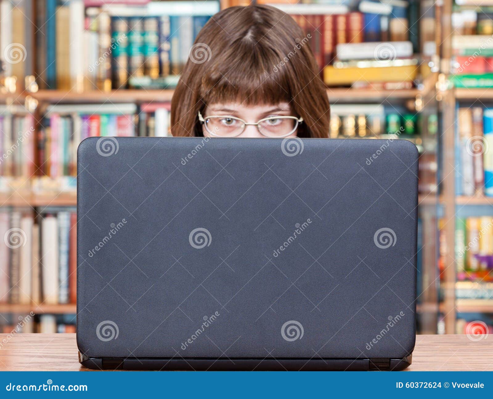 Girl Reads from Laptop Screen in Library Stock Photo - Image of cover ...