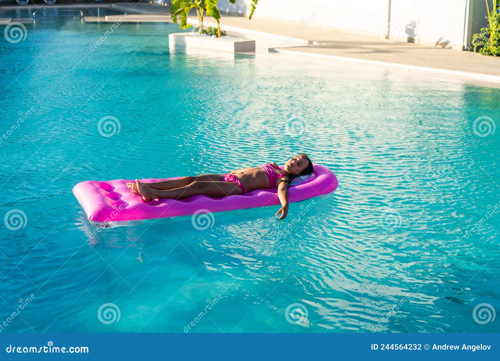 The Girl Relaxes on an Inflatable Mattress in the Pool, Taking Air ...