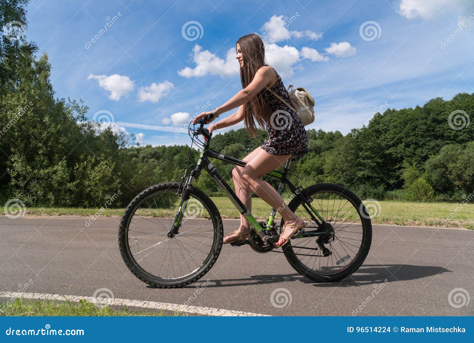 Girl Riding A Bicycle. Side View. Forest And Clouds In The Background ...