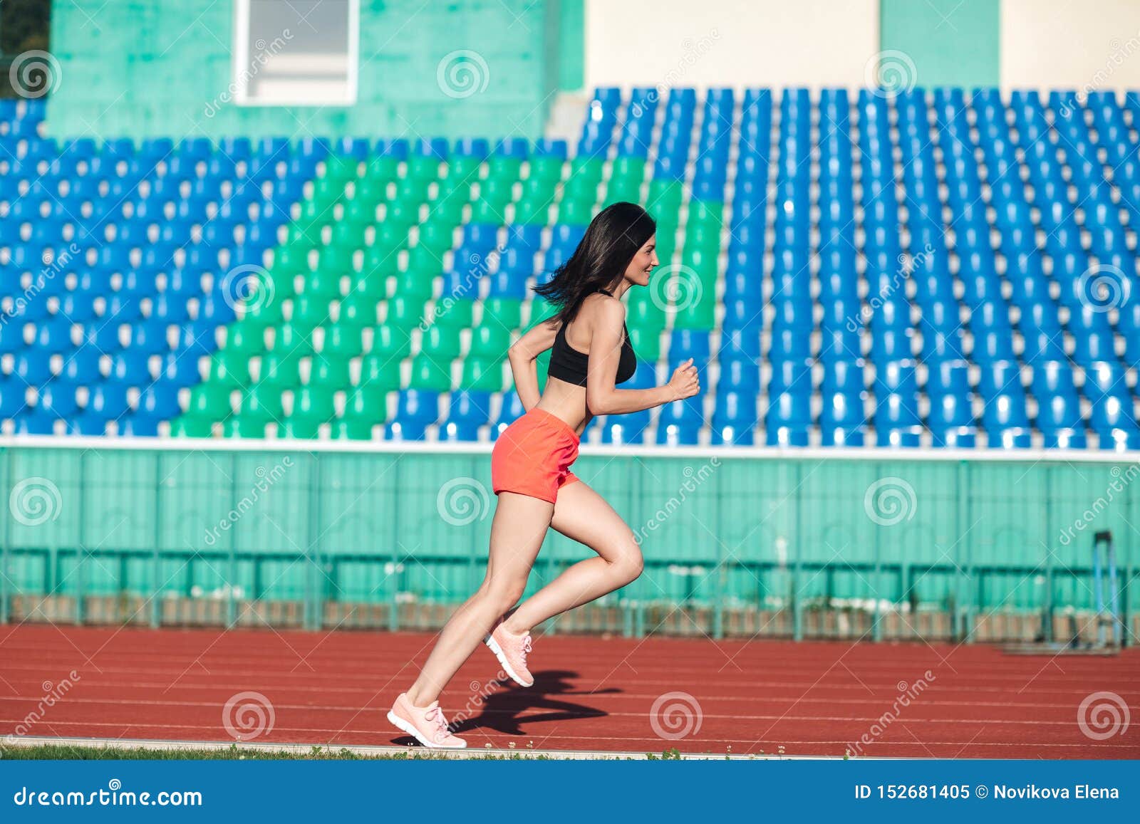 Girl Running Track On Stadium Real Side View Of Young Woman In Pink