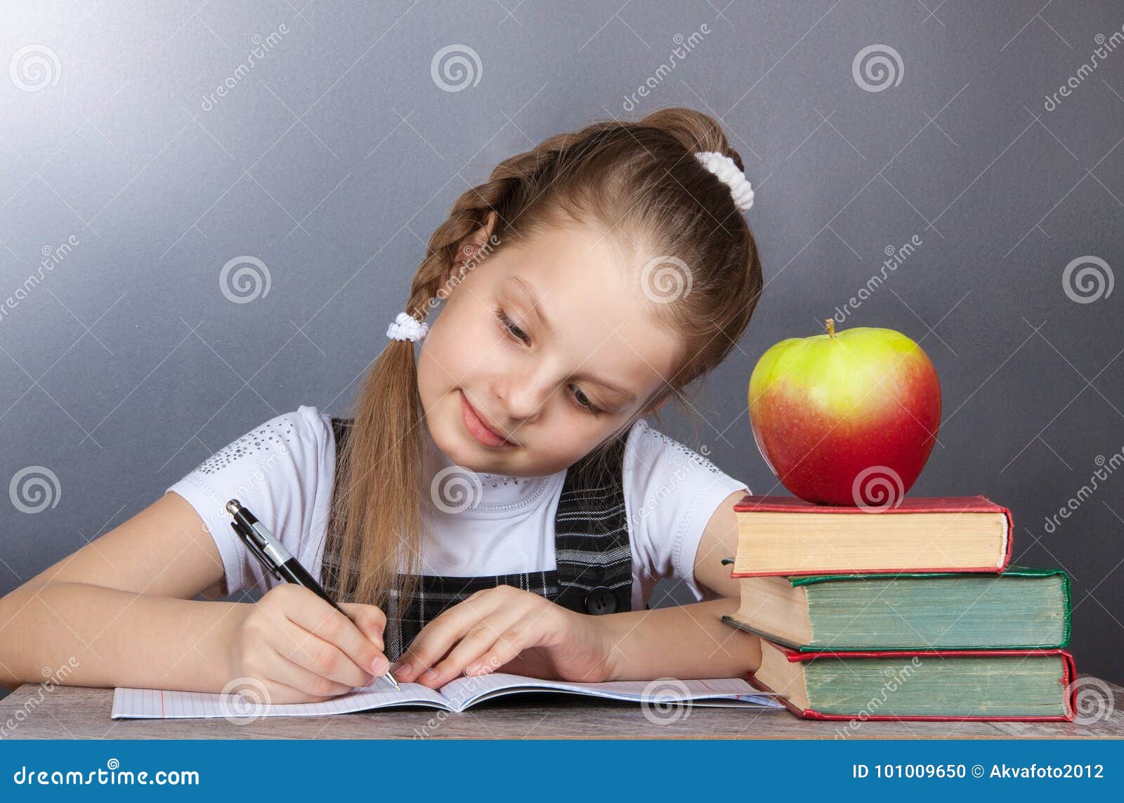 Girl School Girl Writes in a Notebook while Sitting at a Desk. Stock ...