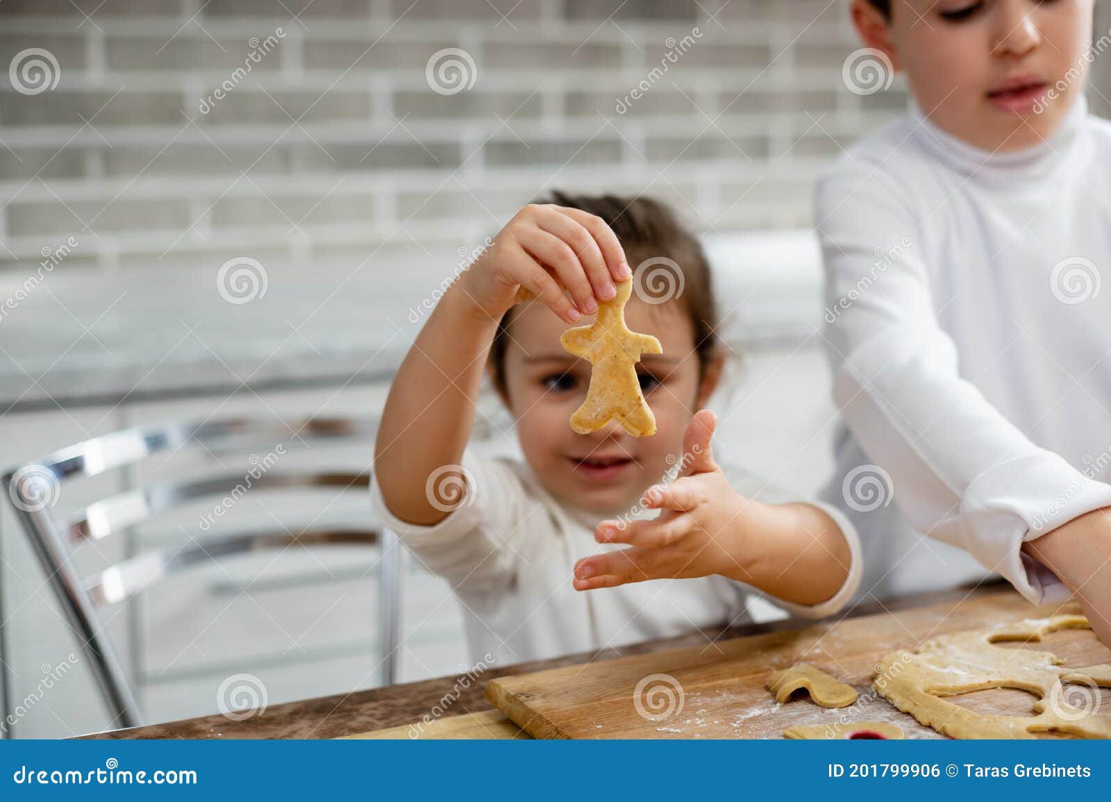 The Girl Shows the Cookie Preparation in the Form of a Man Stock Photo ...