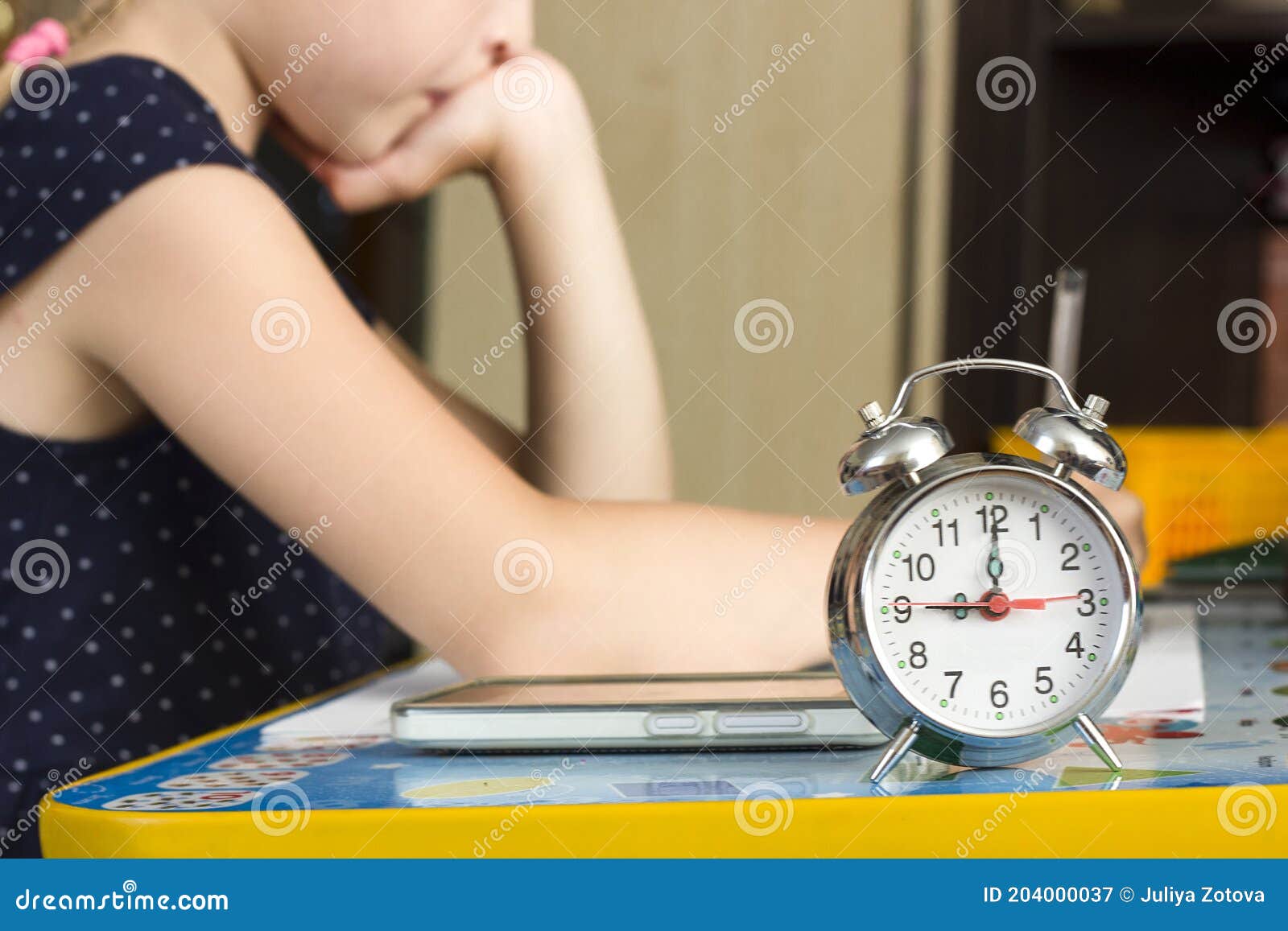 The Girl Sits at the Table and Does Her Homework, the Clock in the ...