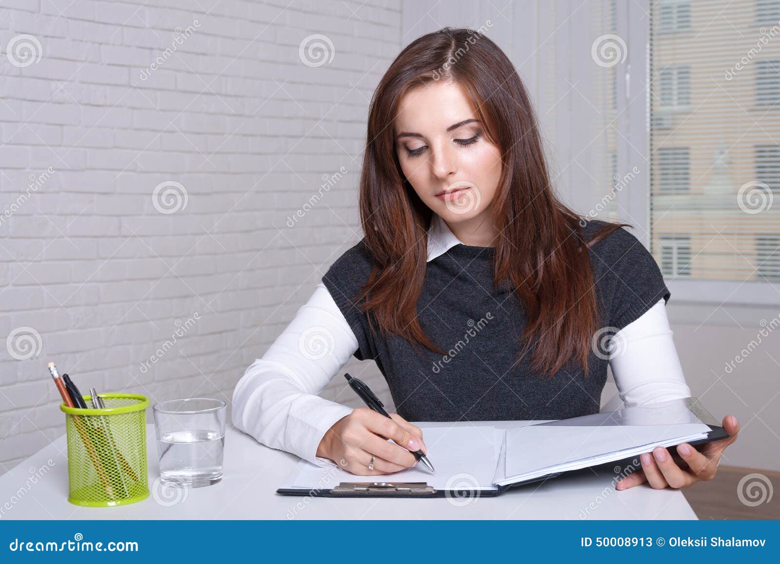 Girl Sits at a Workstation Writes in the Document Folder Stock Image ...