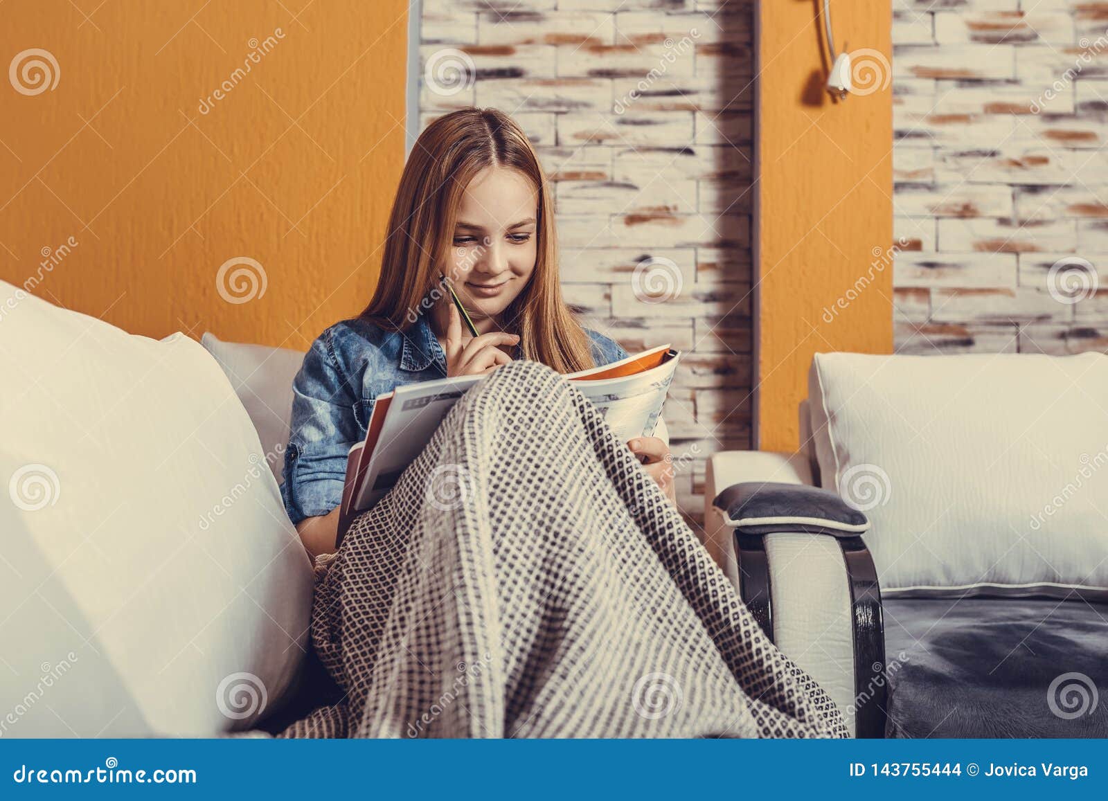 Girl Sitting on a Bed Covered with a Blanket and Studying before the ...