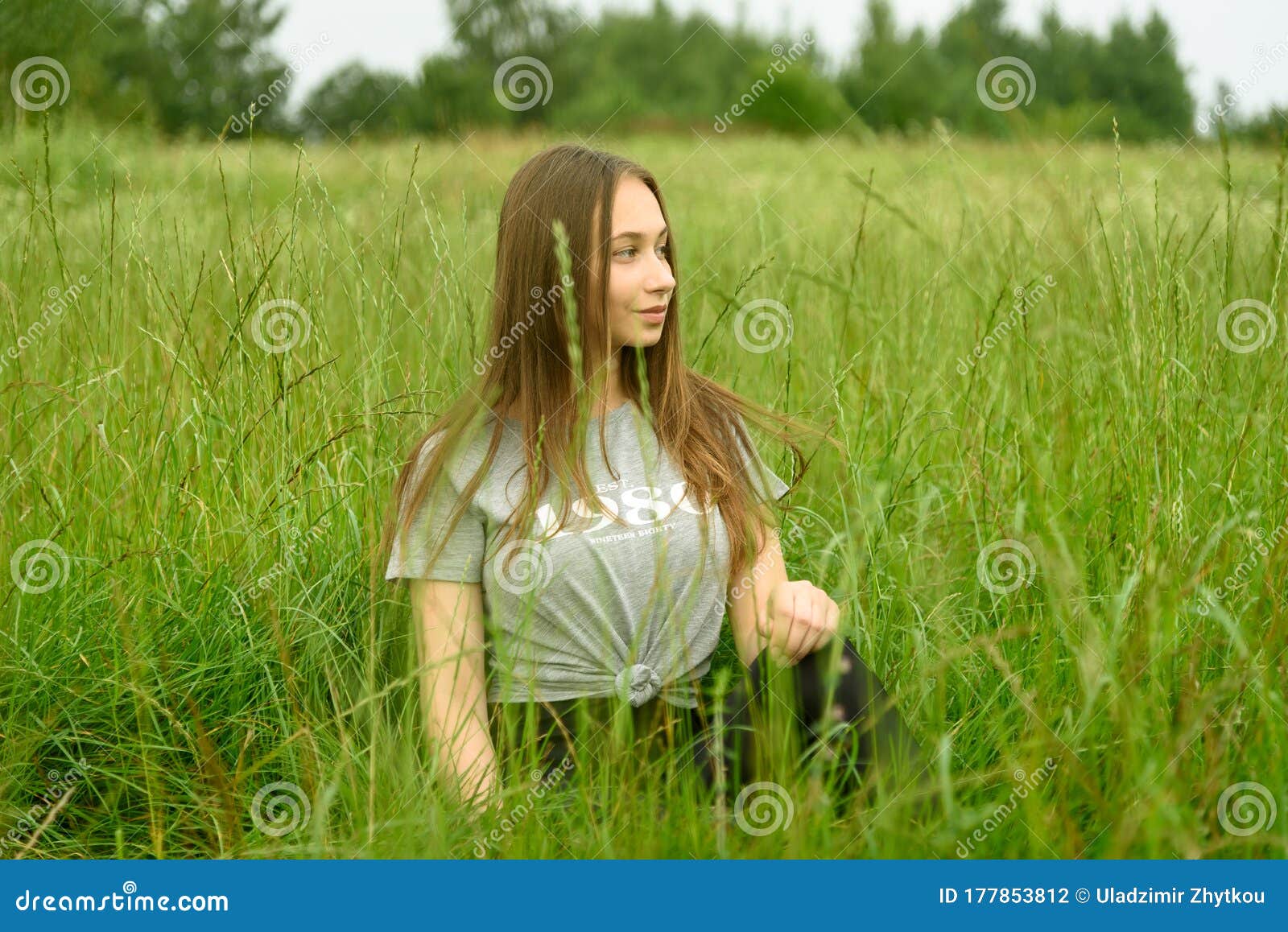 Girl Sitting in the Grass in the Meadow. Stock Photo - Image of ...