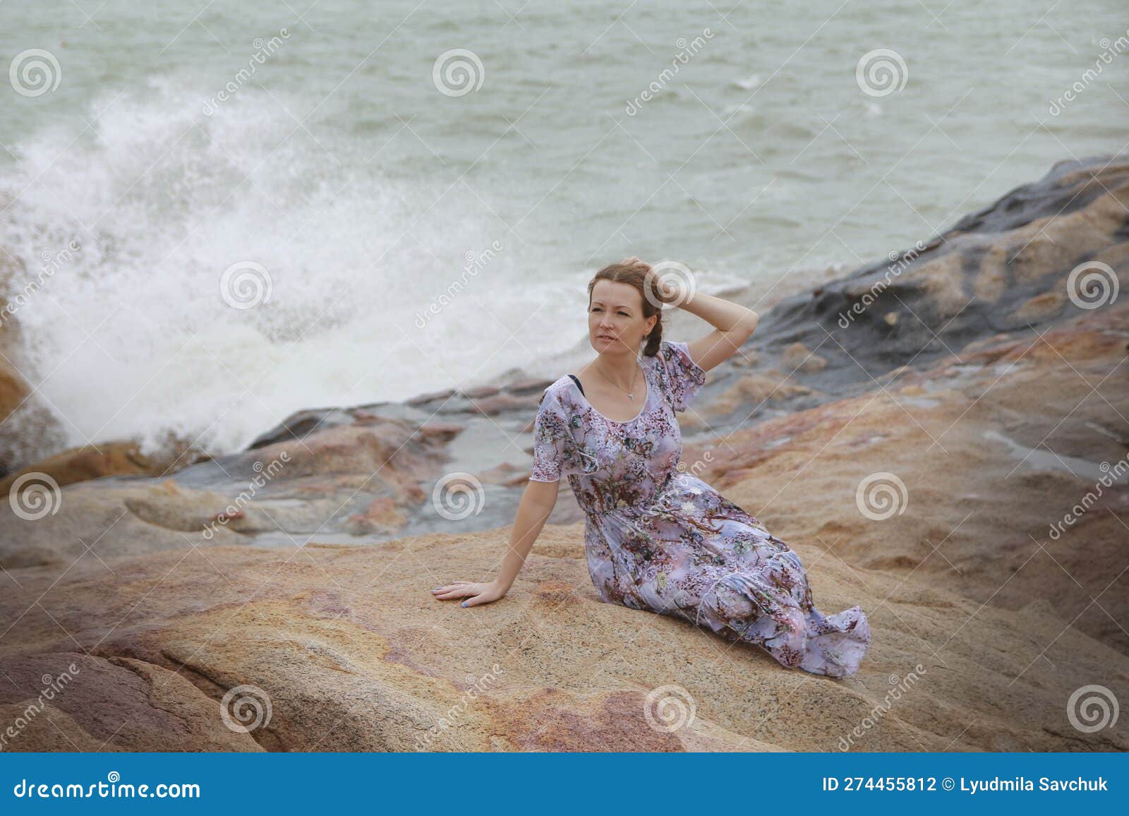 The Girl is Sitting on a Large Rock, on Which the Waves are Breaking ...