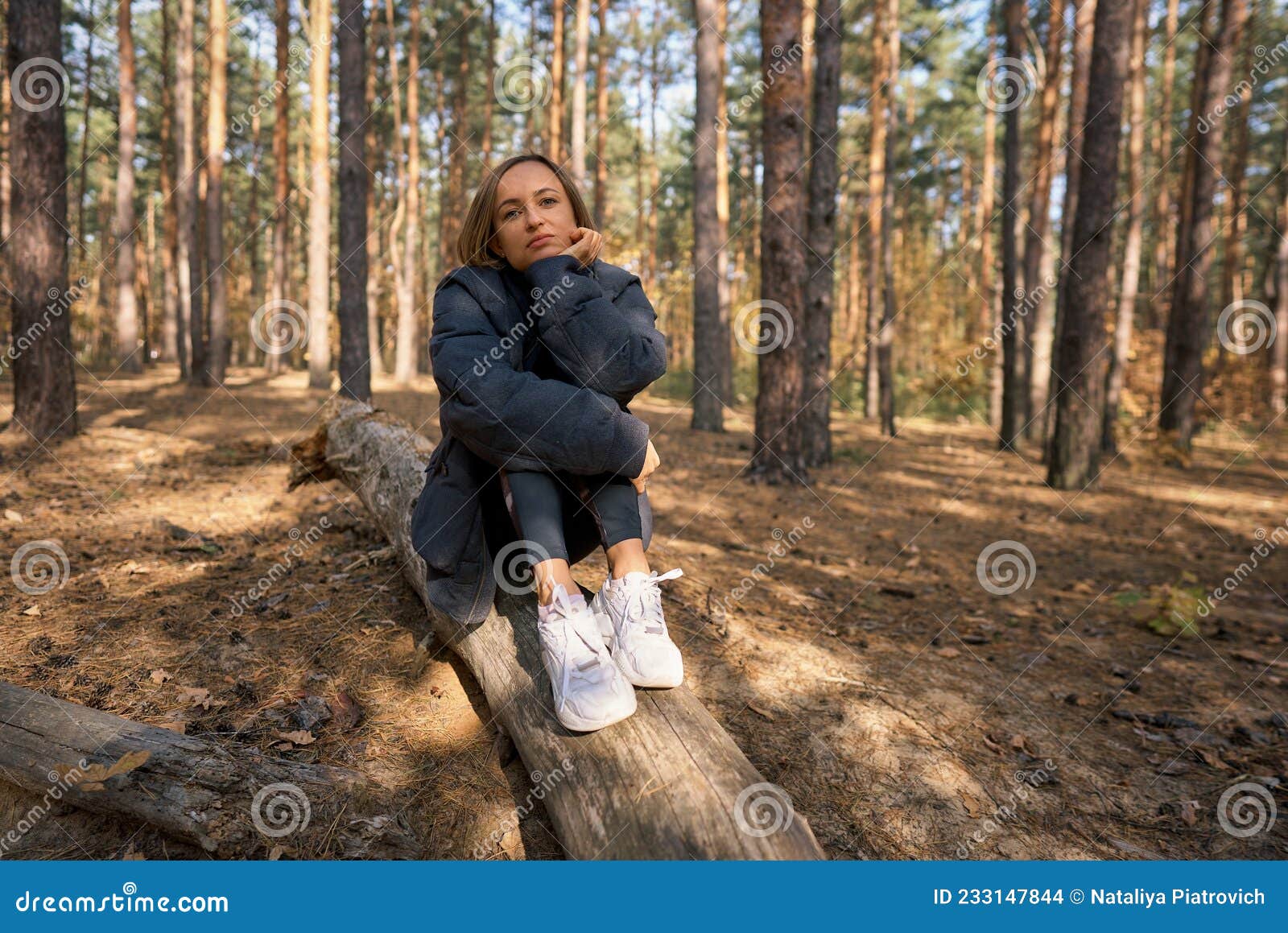 Girl Sitting on a Log in a Pine Forest in Autumn. Stock Photo - Image ...