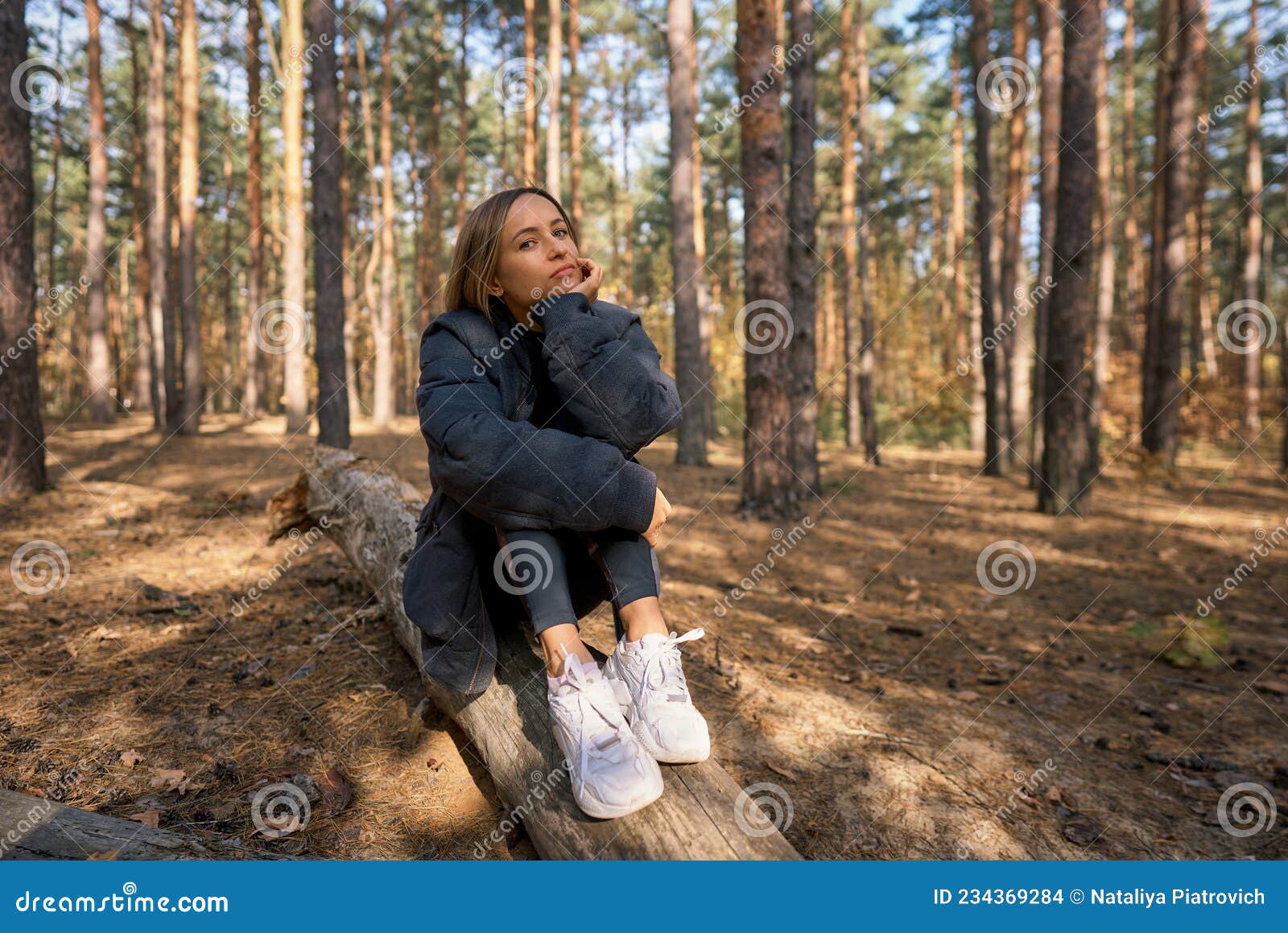 Girl Sitting on a Log in a Pine Forest in Autumn. Stock Photo - Image ...