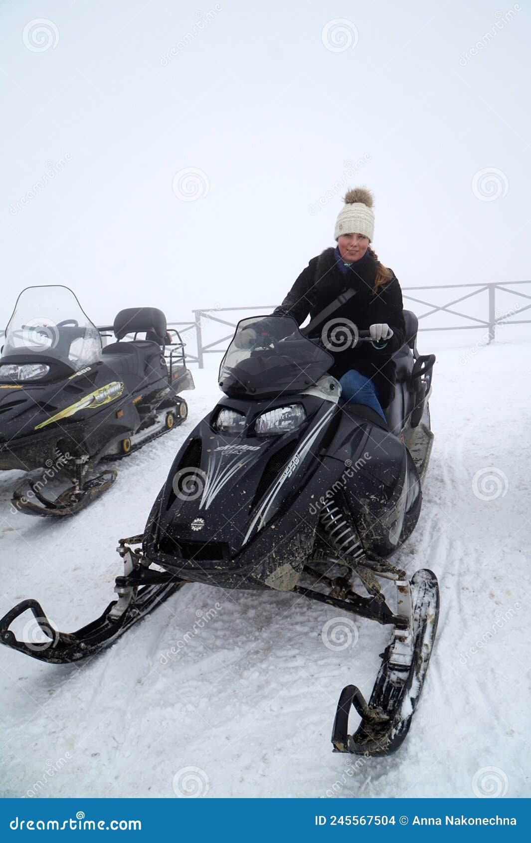 The Girl is Sitting on a Snowmobile on Top of a Mountain. Stock Photo ...