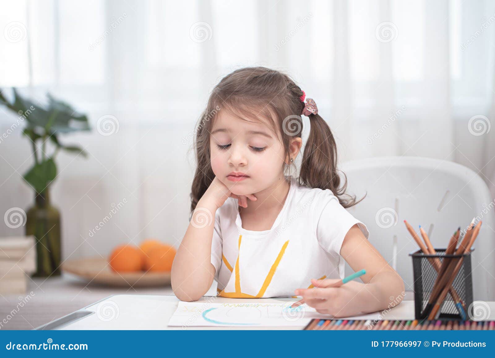 The Girl is Sitting at the Table and Doing Homework. the Child Learns ...