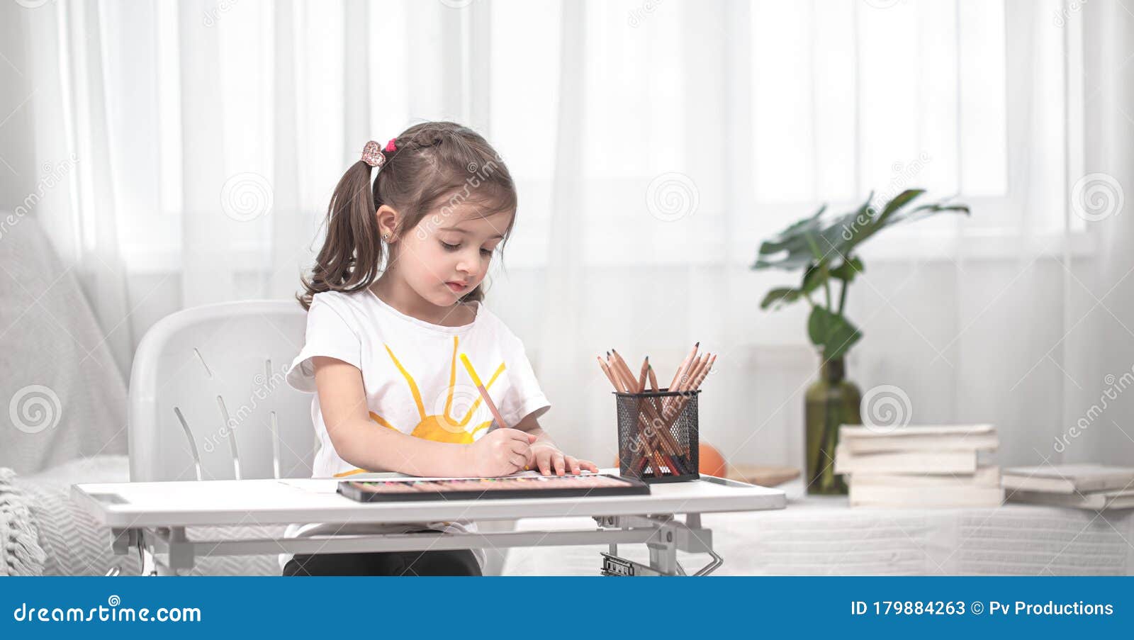 The Girl is Sitting at the Table and Doing Homework. the Child Learns ...